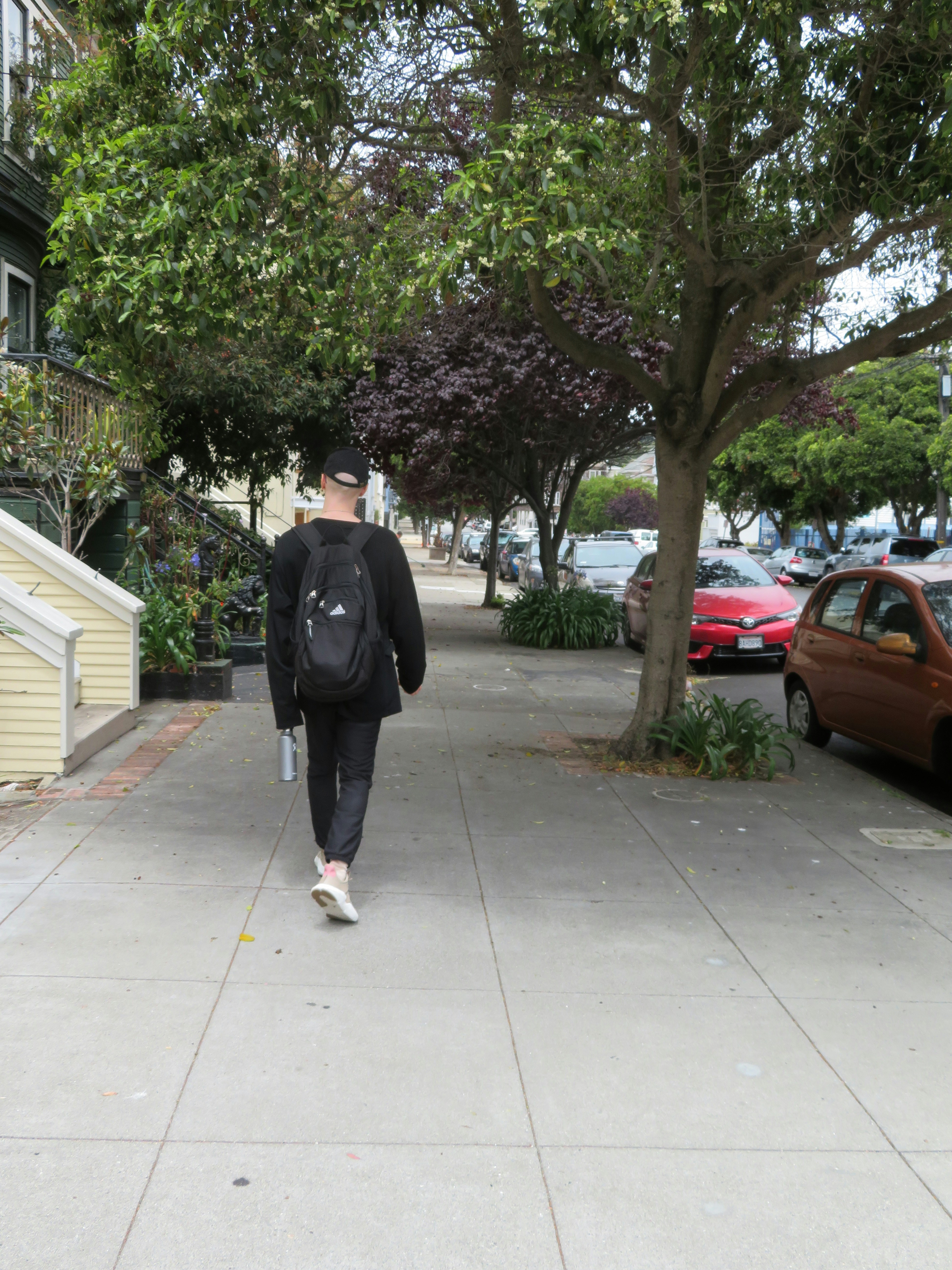 a man with a backpack walking down a sidewalk