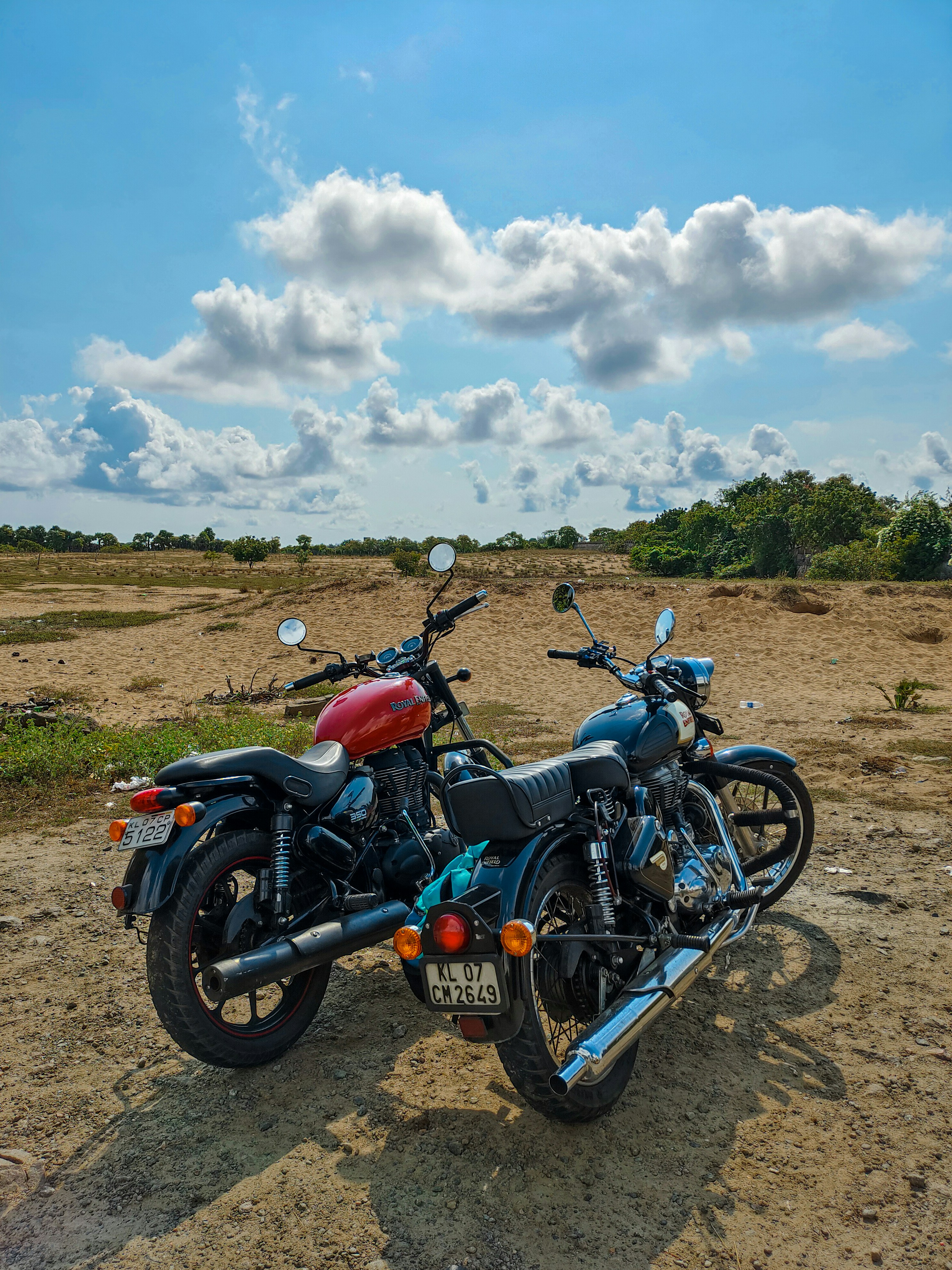 Red and Blue Retro Motorcycles Rest on a Dusty Plateau Under a Wide Sky