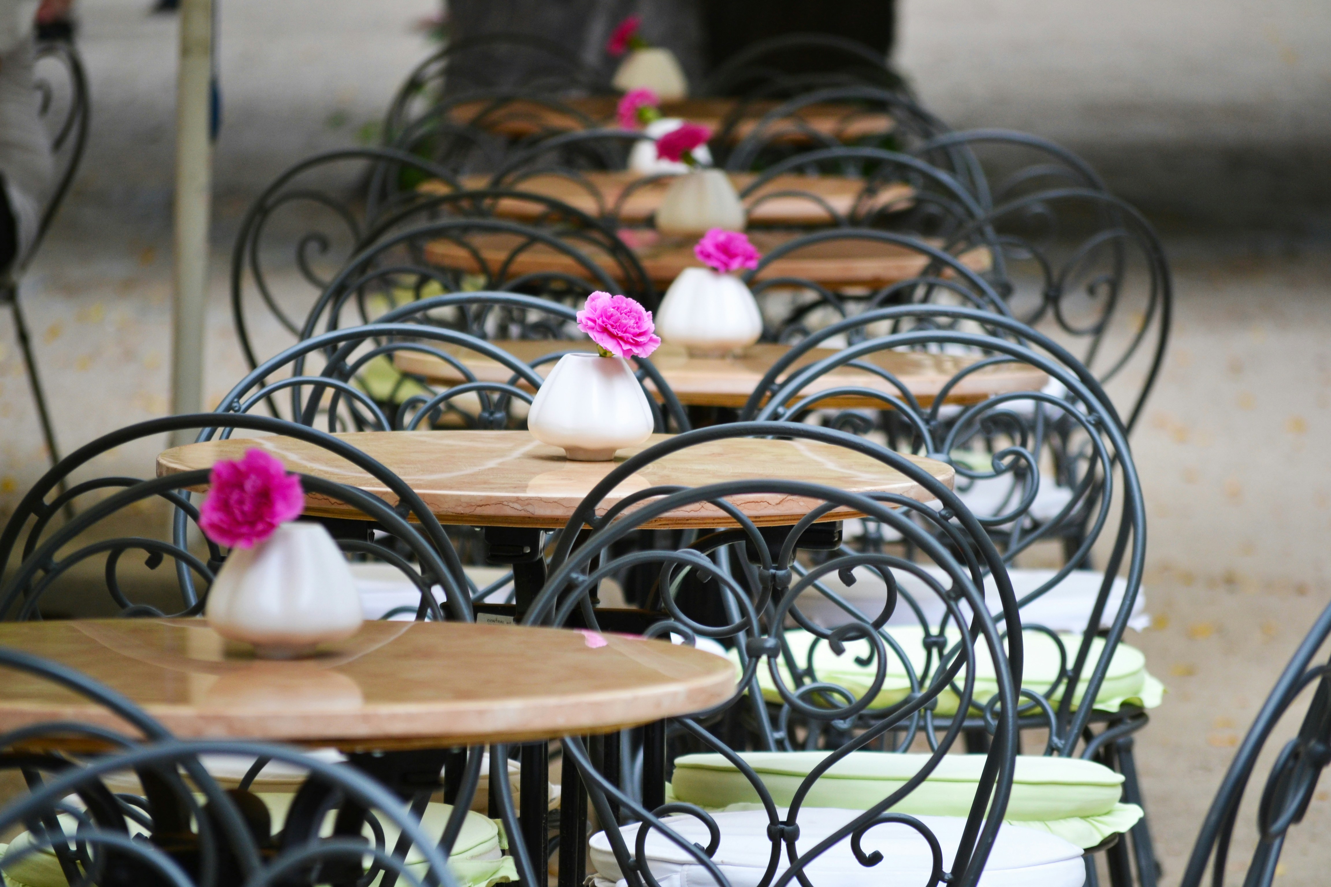 Elegant café tables adorned with delicate flower arrangements, inviting patrons to enjoy a serene dining experience.