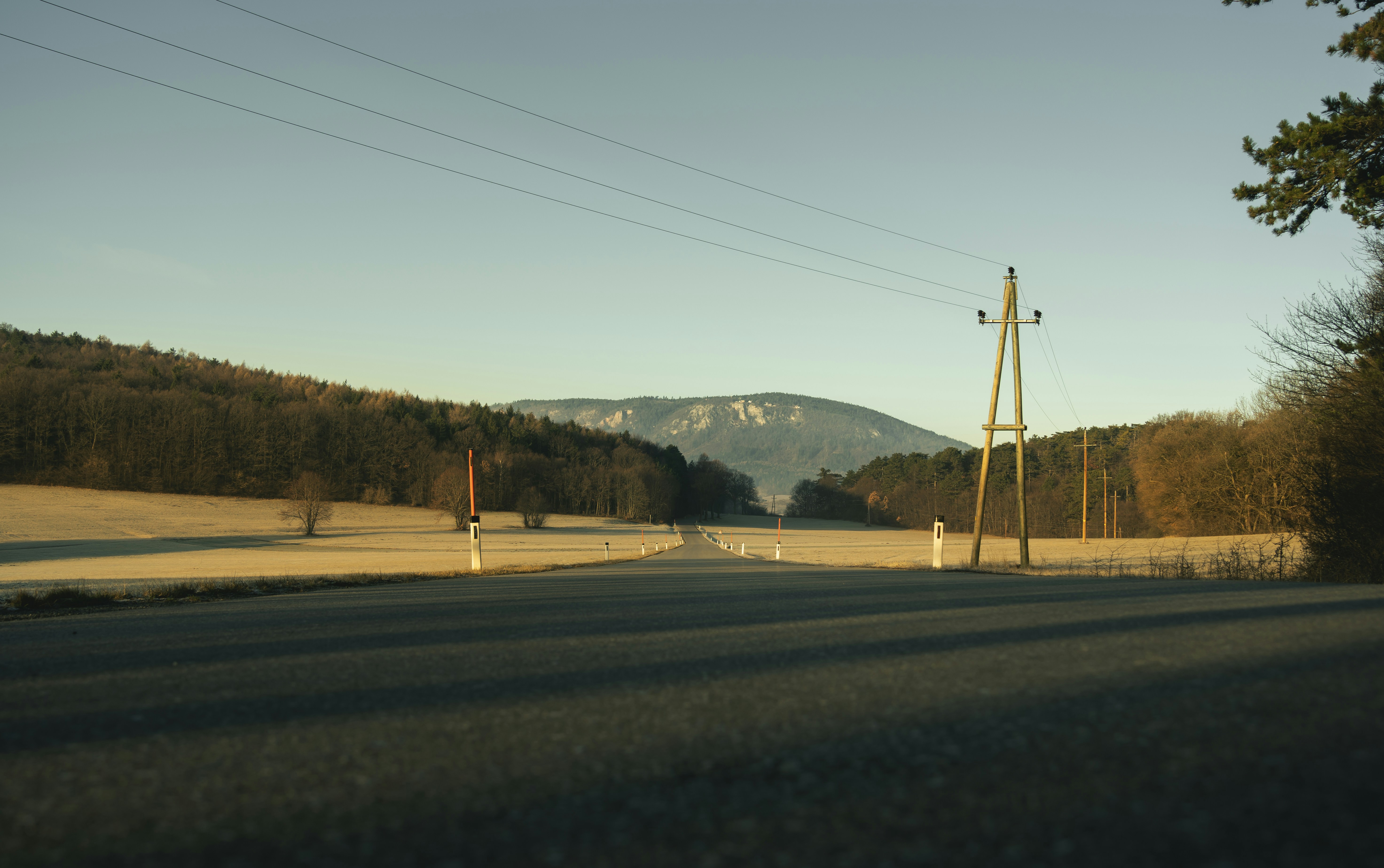 The Long Approach: Rural Road Piercing a Mountain Horizon at Golden Hour