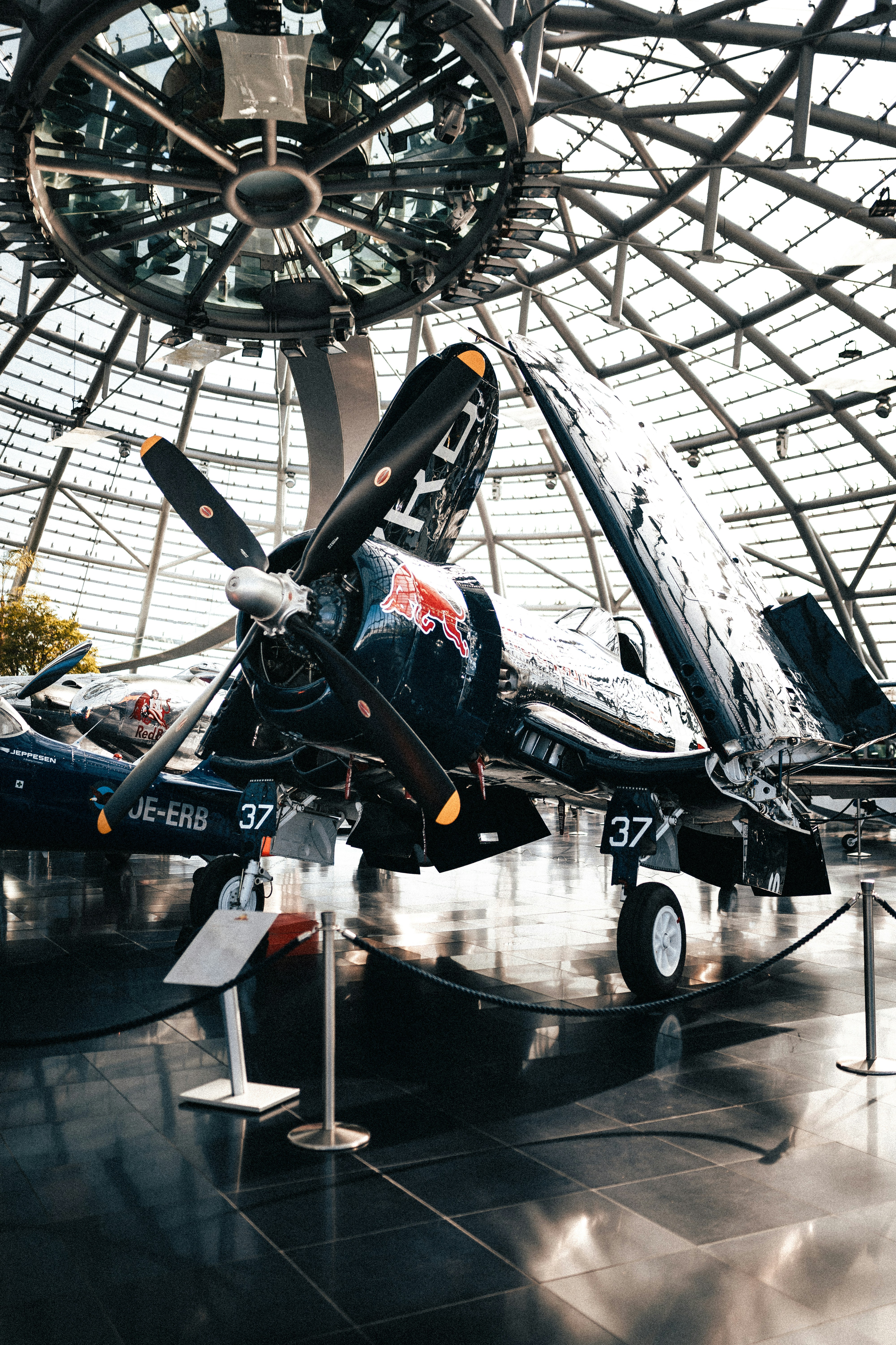 Classic fighter aircraft displayed under a striking glass dome, showcasing its intricate details and vintage design.