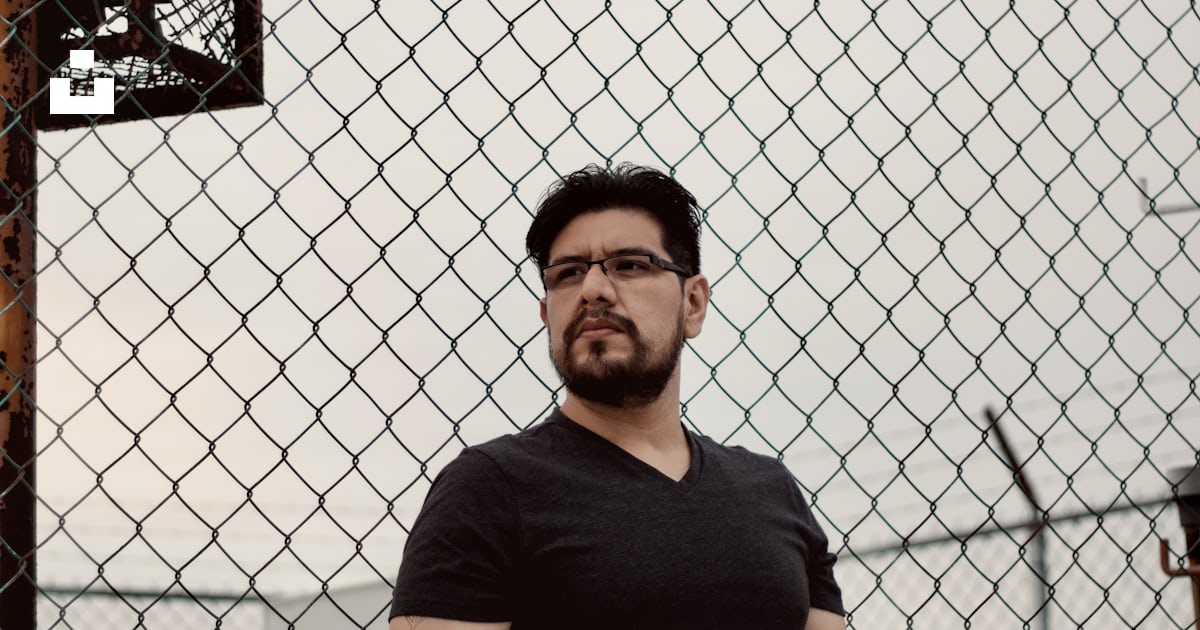 A Man Standing In Front Of A Chain Link Fence Photo Free México Image