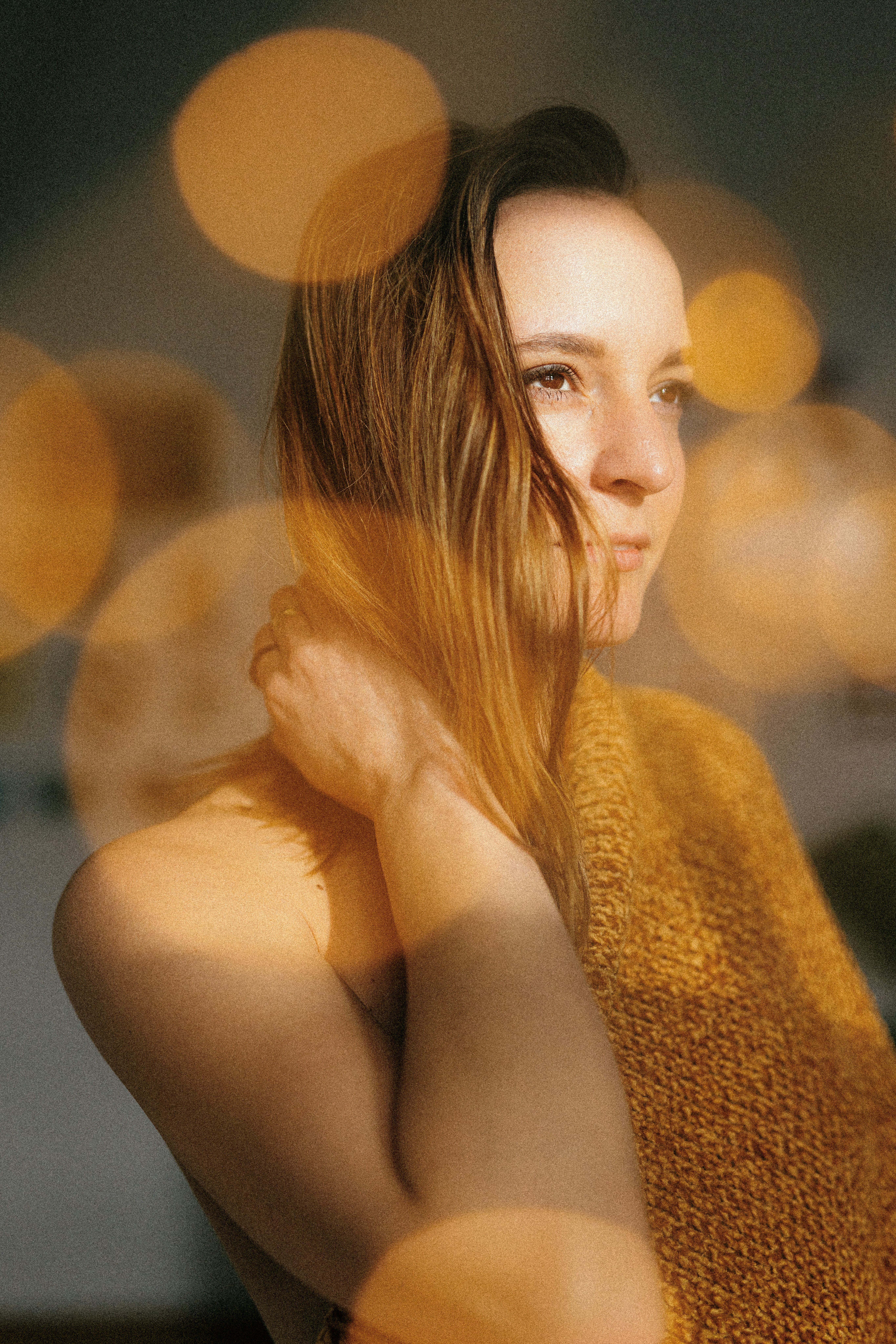 Woman in soft focus with warm, golden bokeh lights surrounding her.