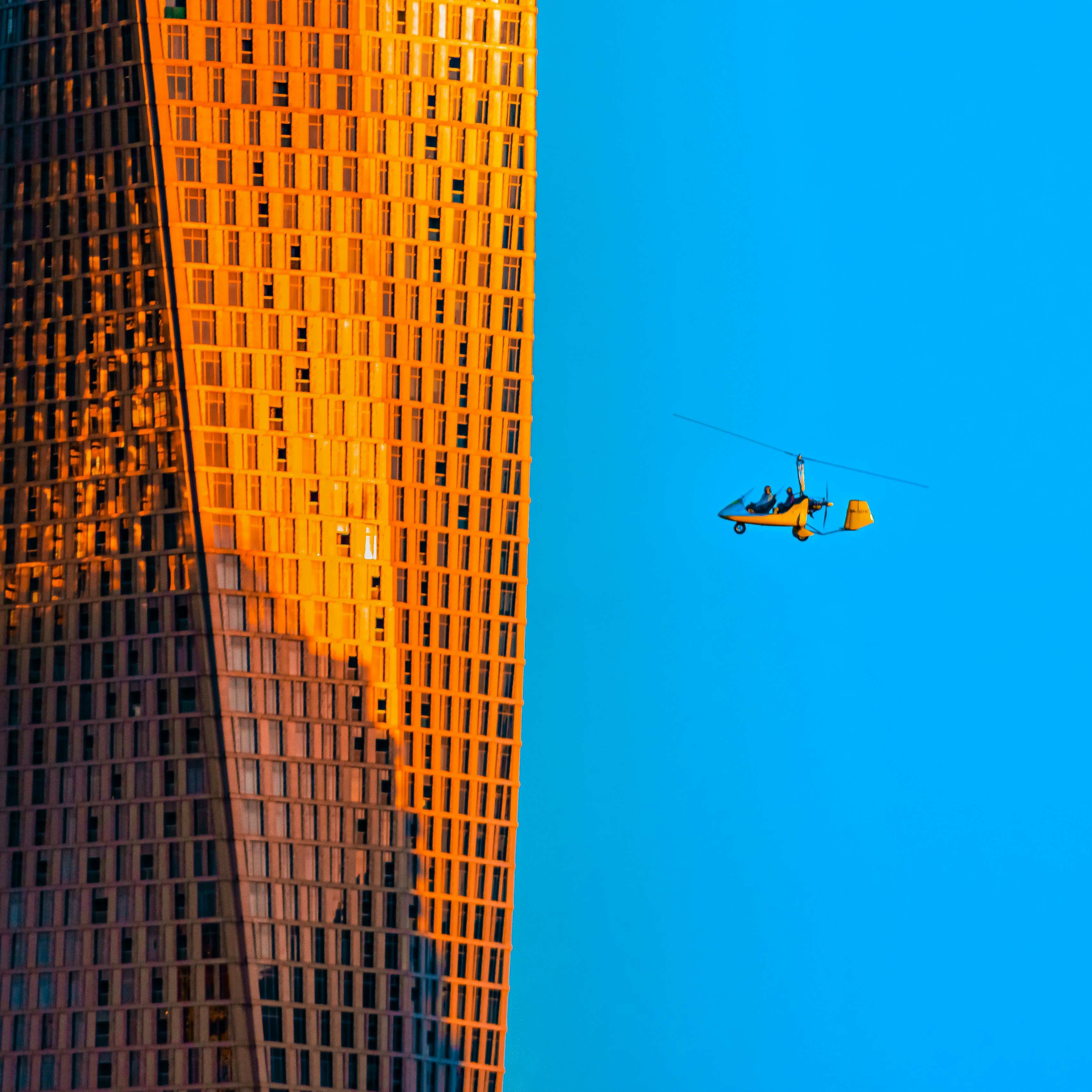 A plane flying in front of a tall building photo – Free Transportation ...