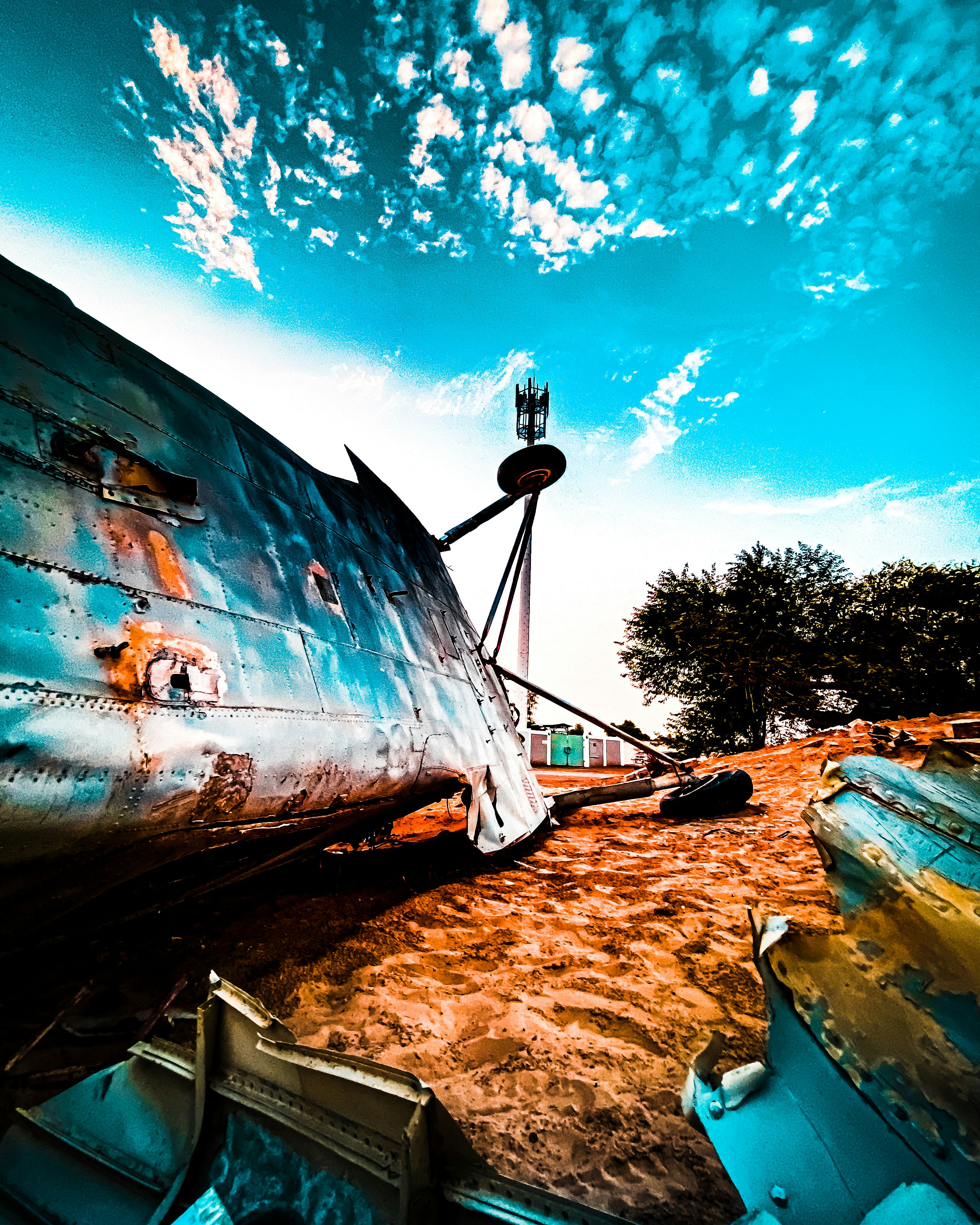 A rusted airplane sitting on top of a dirt field photo – Free ...