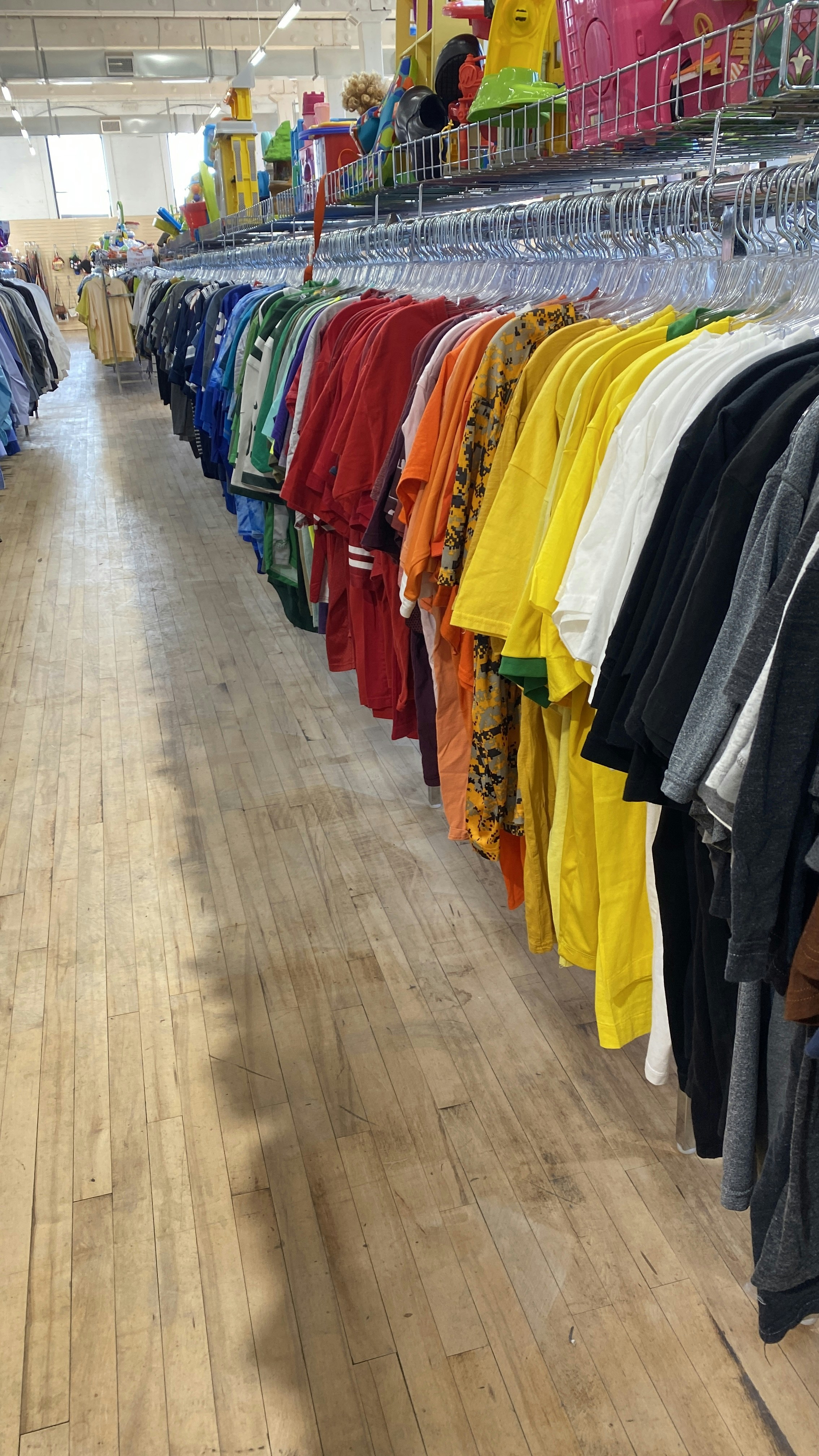 A row of shirts hanging on a rack in a store photo – Free Thrifting ...