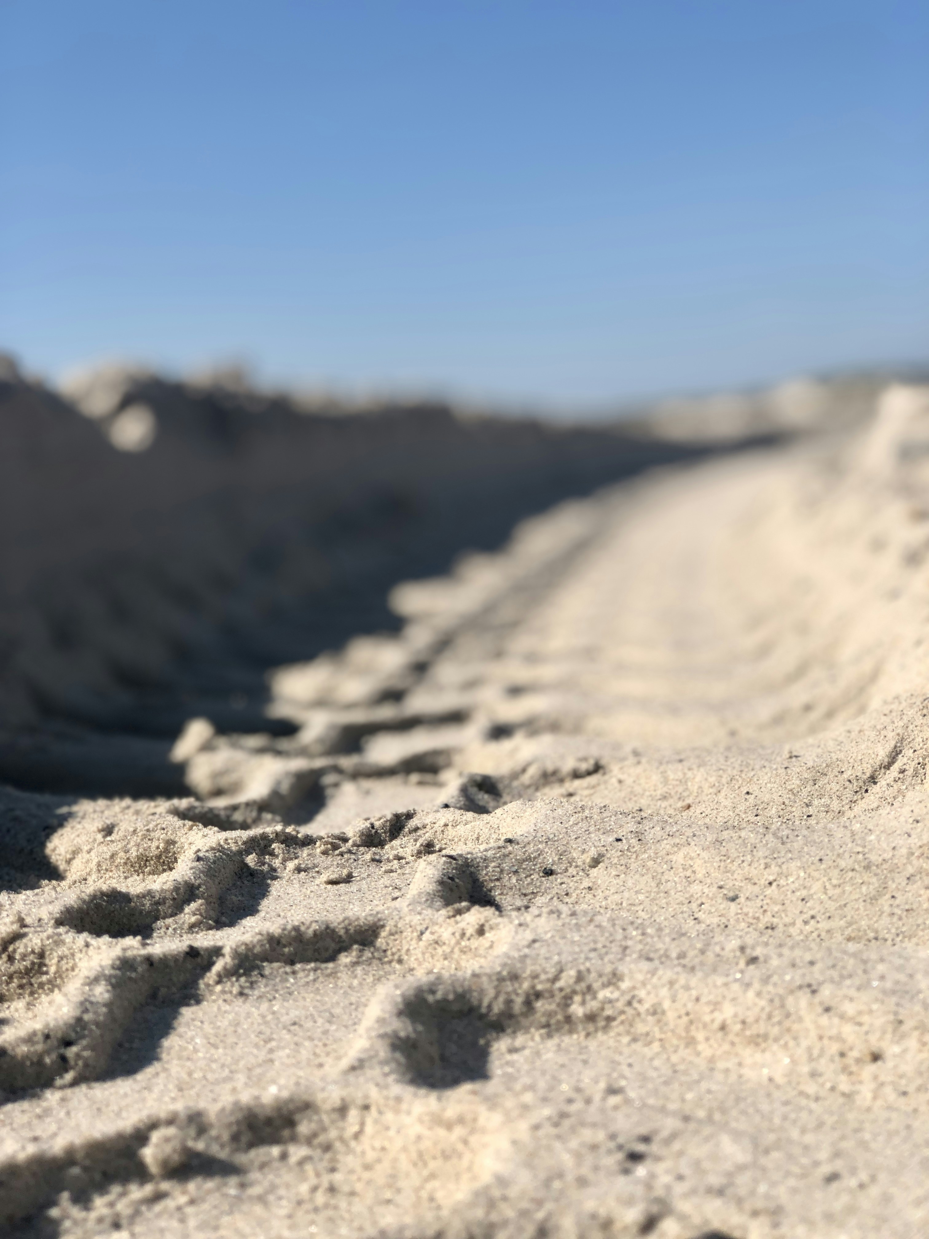 a close up of a sand dune with a blue sky in the background