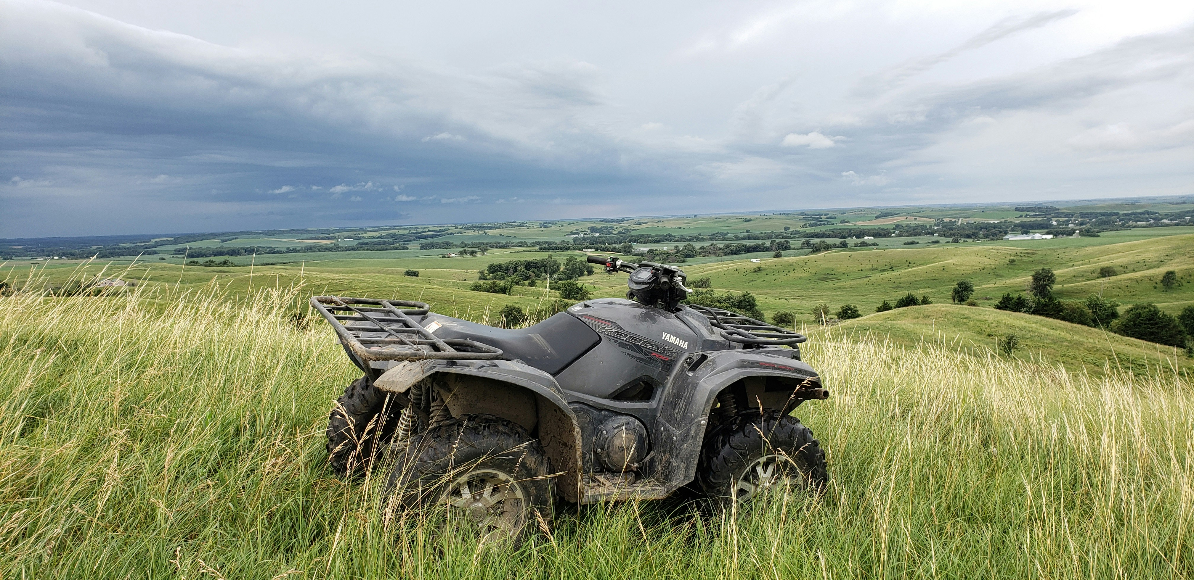 A four - wheeler sits in a grassy field on a cloudy day photo – Free ...