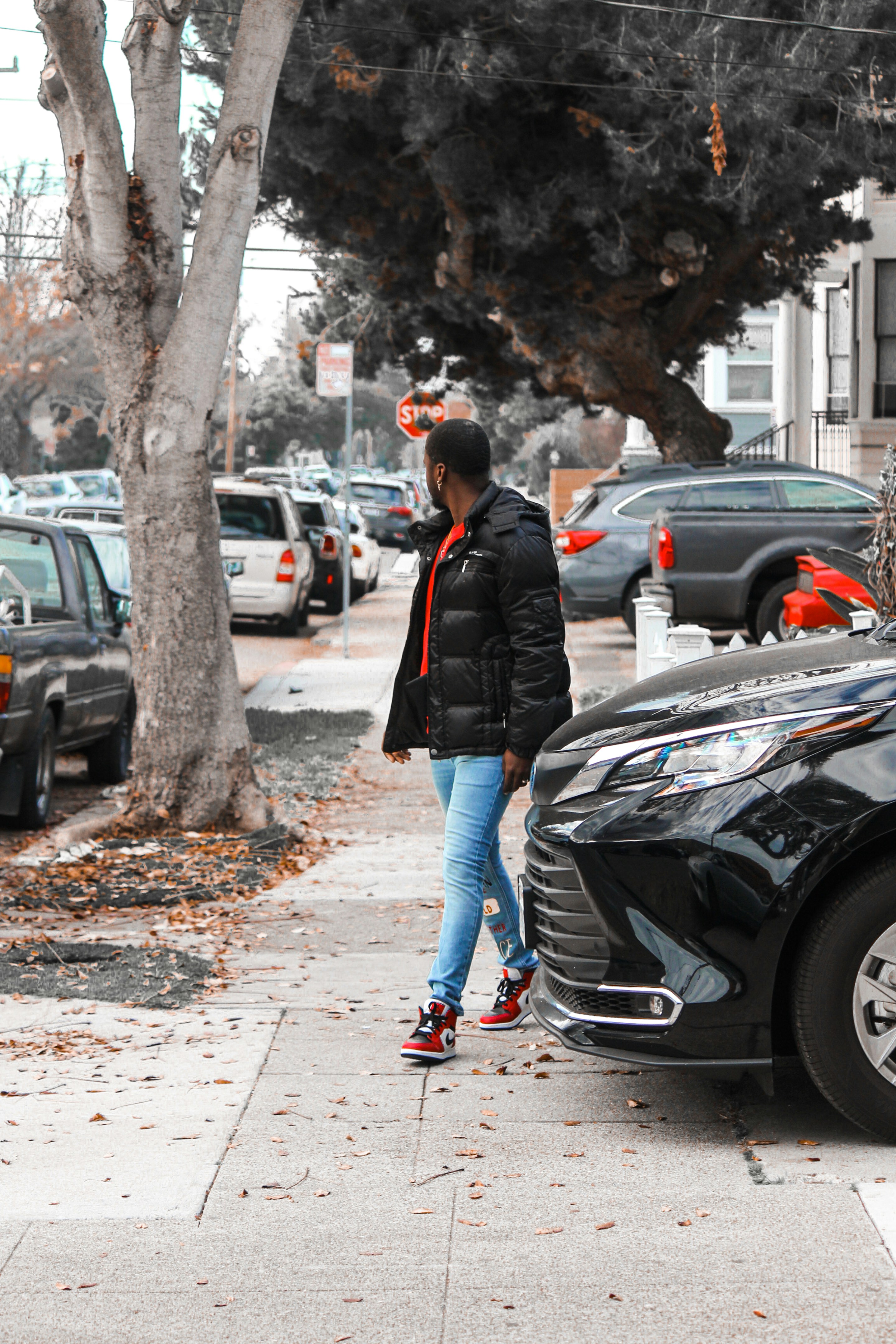 A woman standing next to a parked car on a sidewalk photo – Free ...