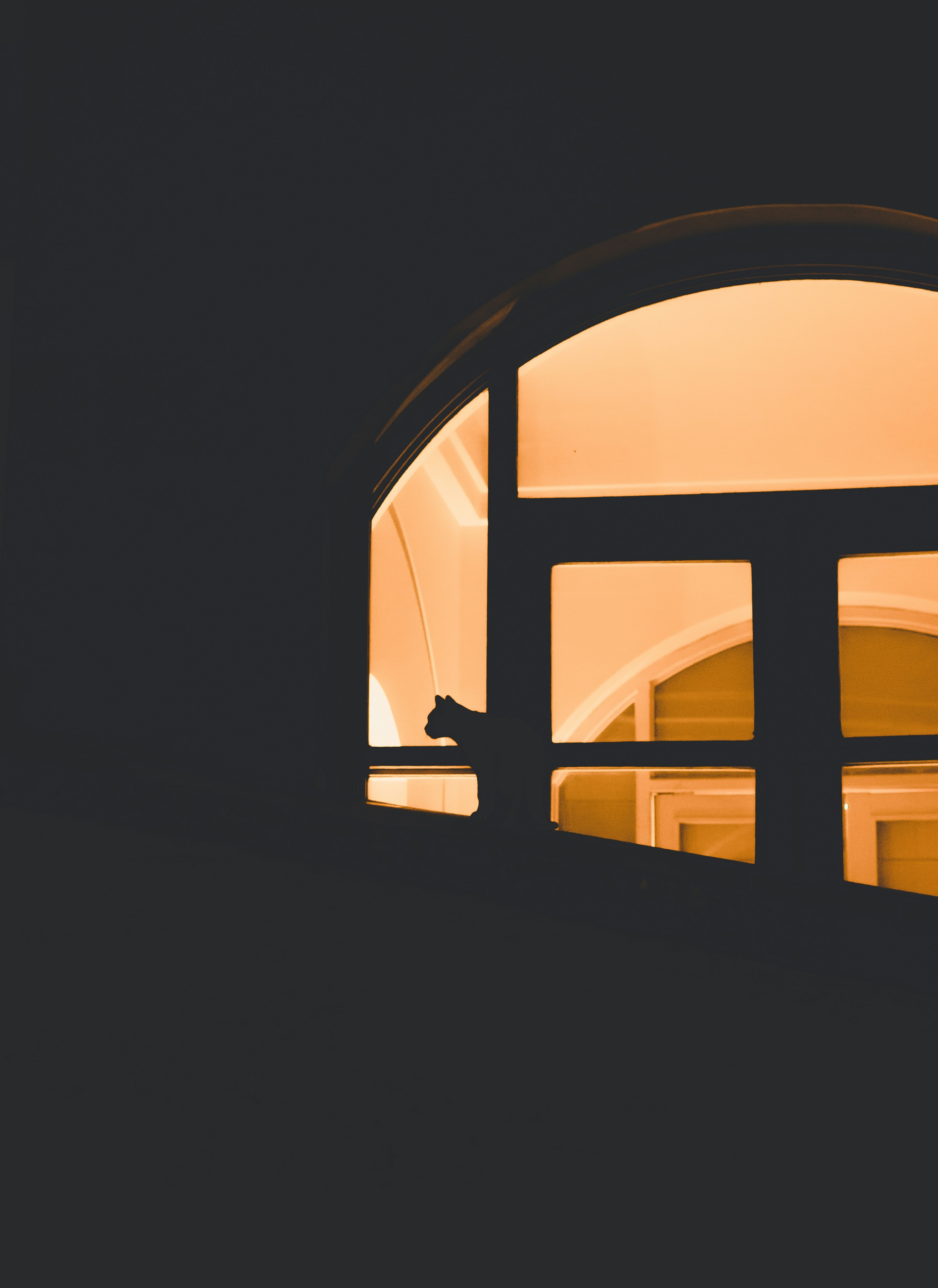 Ember Arch: Warm Light Filtering Through a Shadowed Arched Window