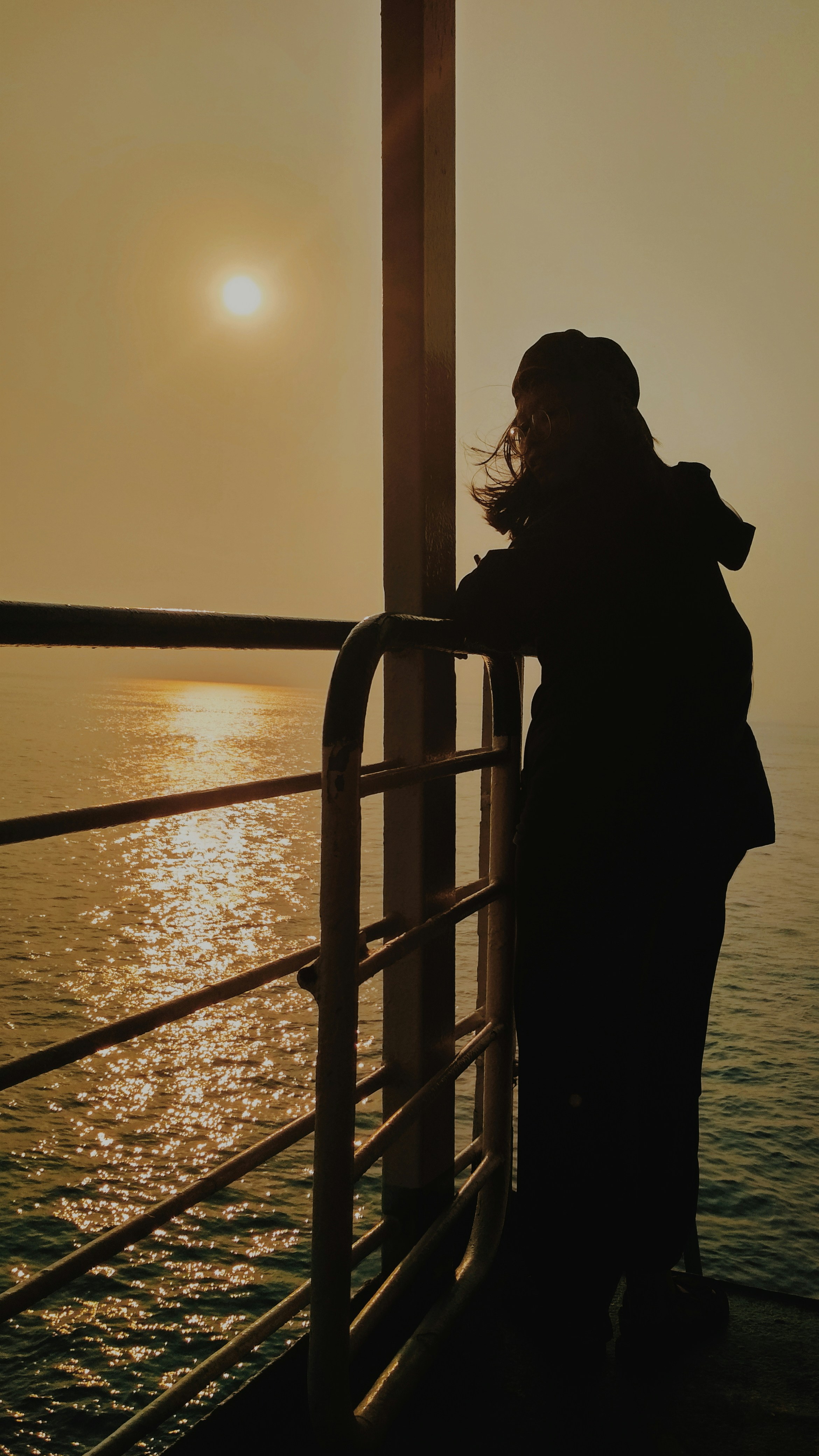 Sunlit Silhouette Over the Pier: Quiet Contemplation by the Sea