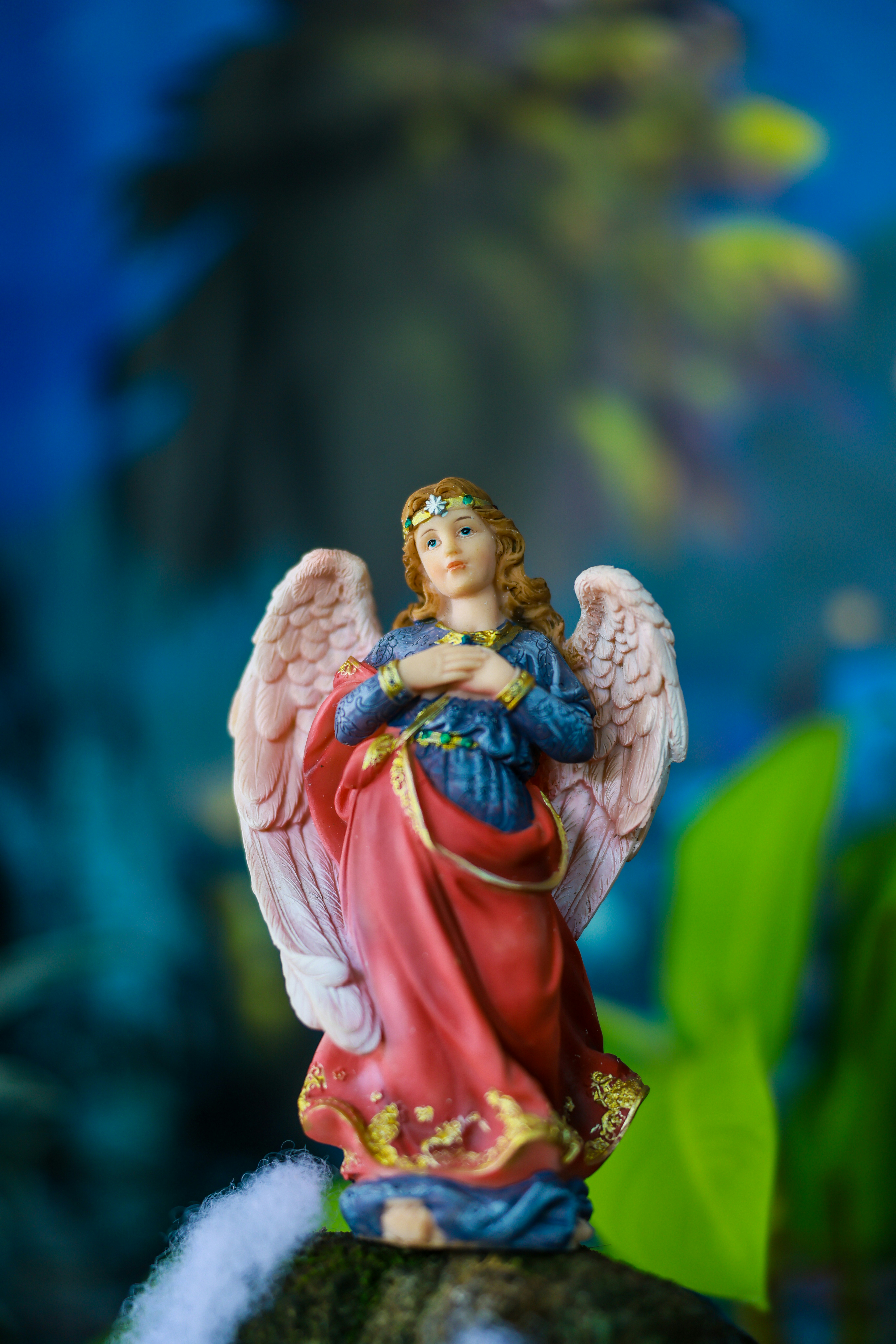 a statue of an angel sitting on top of a rock