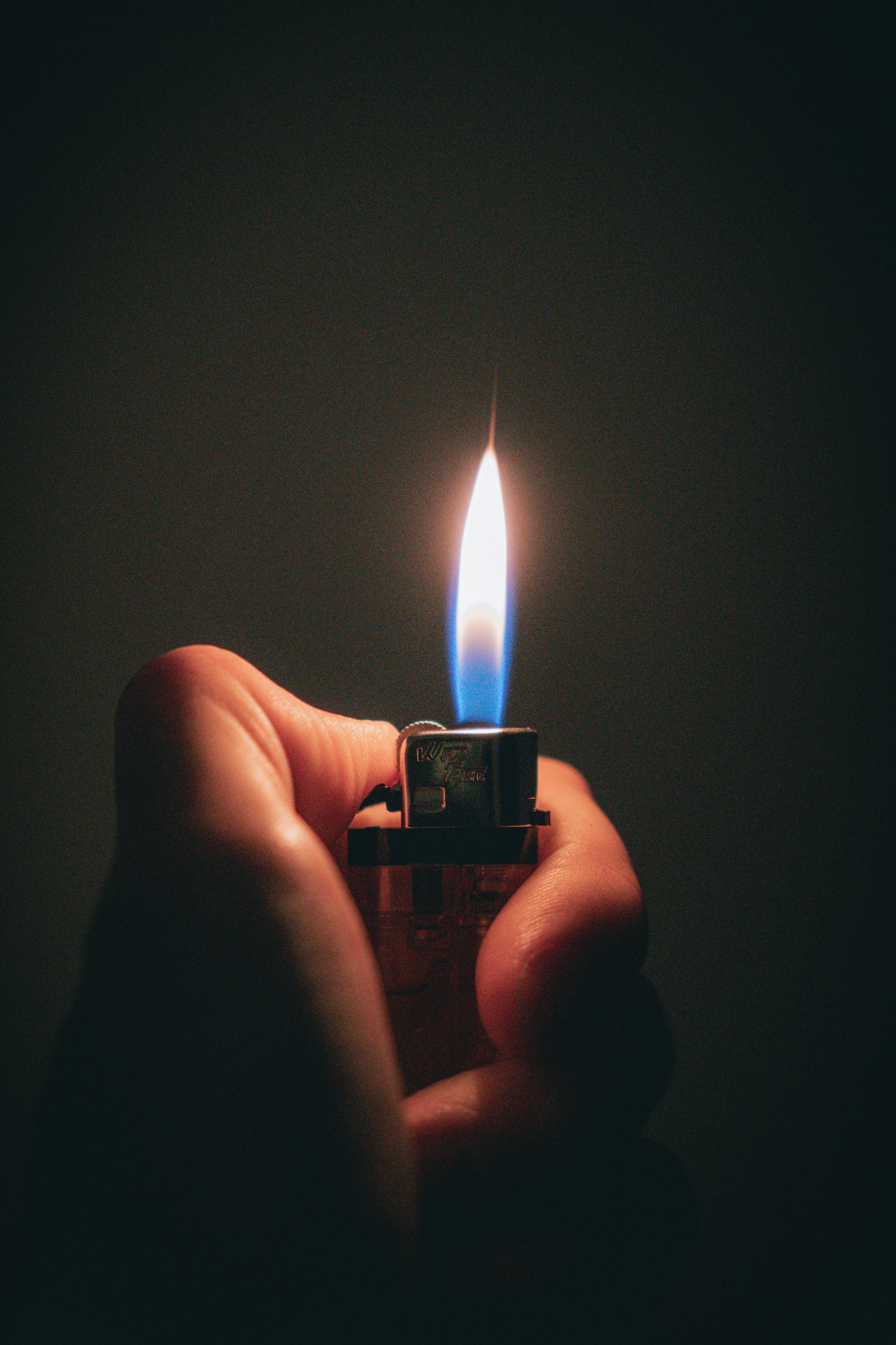 Let us ignite a light. | a person holding a lighter in their hand