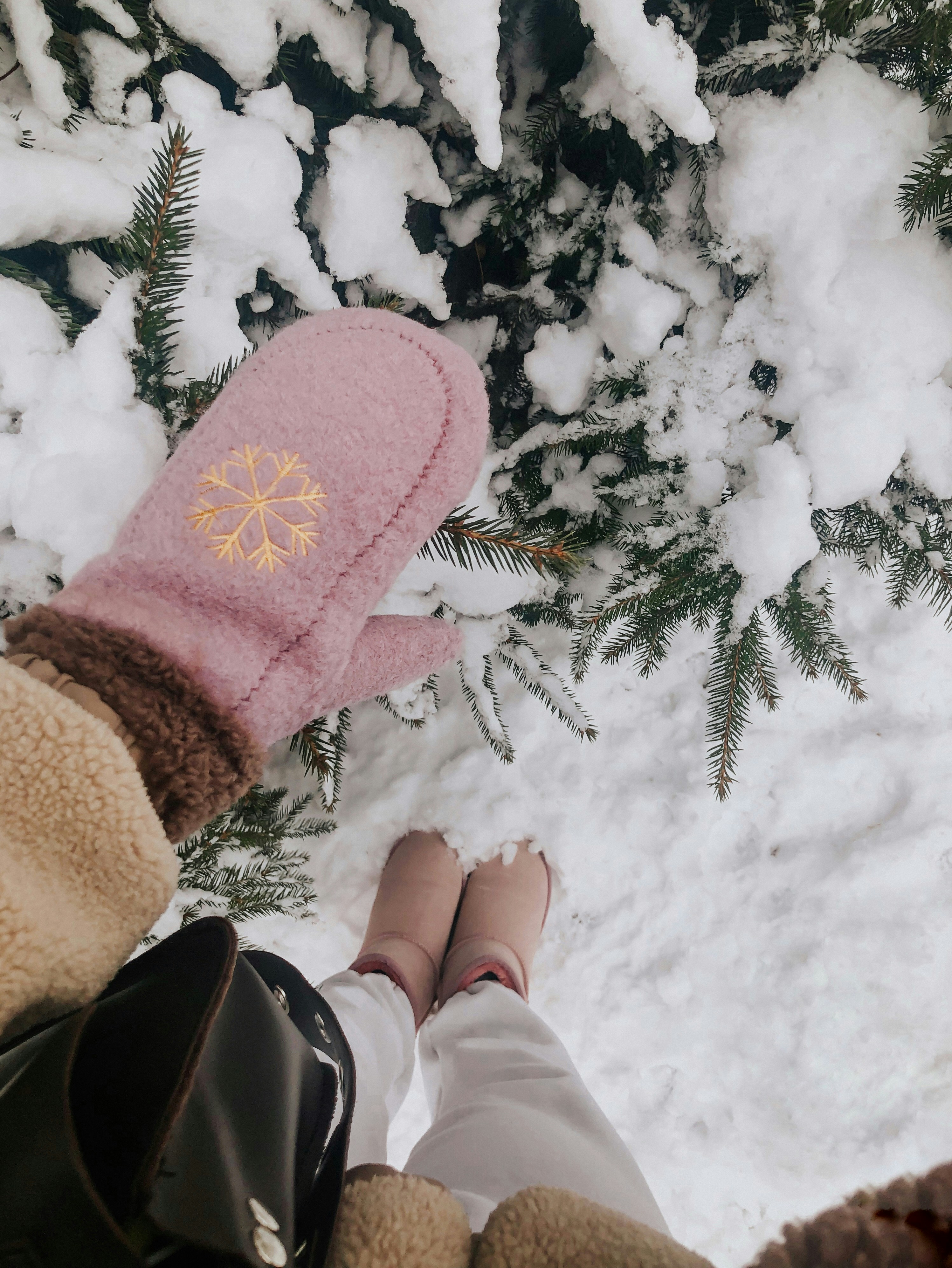 A person standing in the snow with their feet up