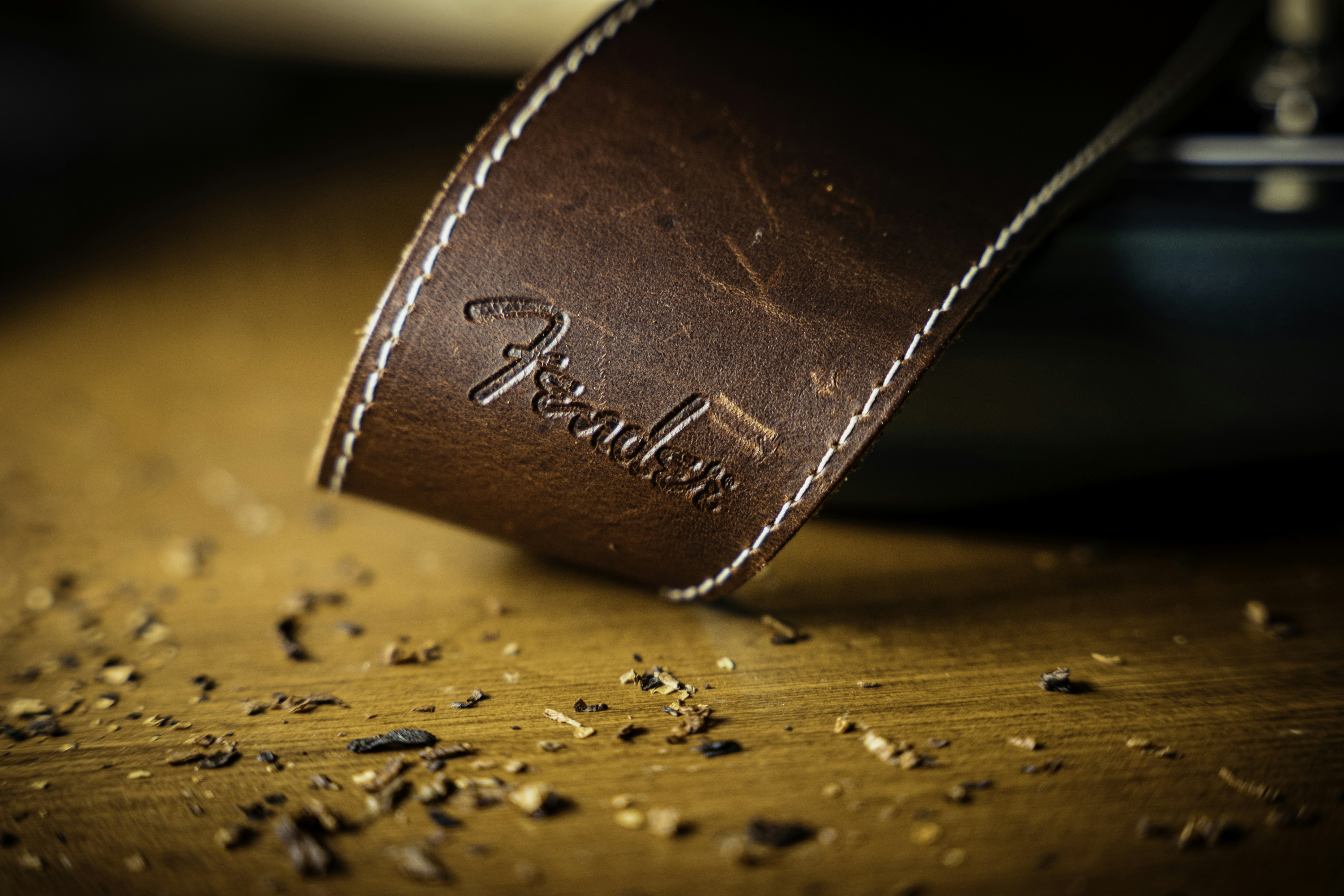 Edge of Craft: Close-Up of a Leather Camera Strap on Warm Wood
