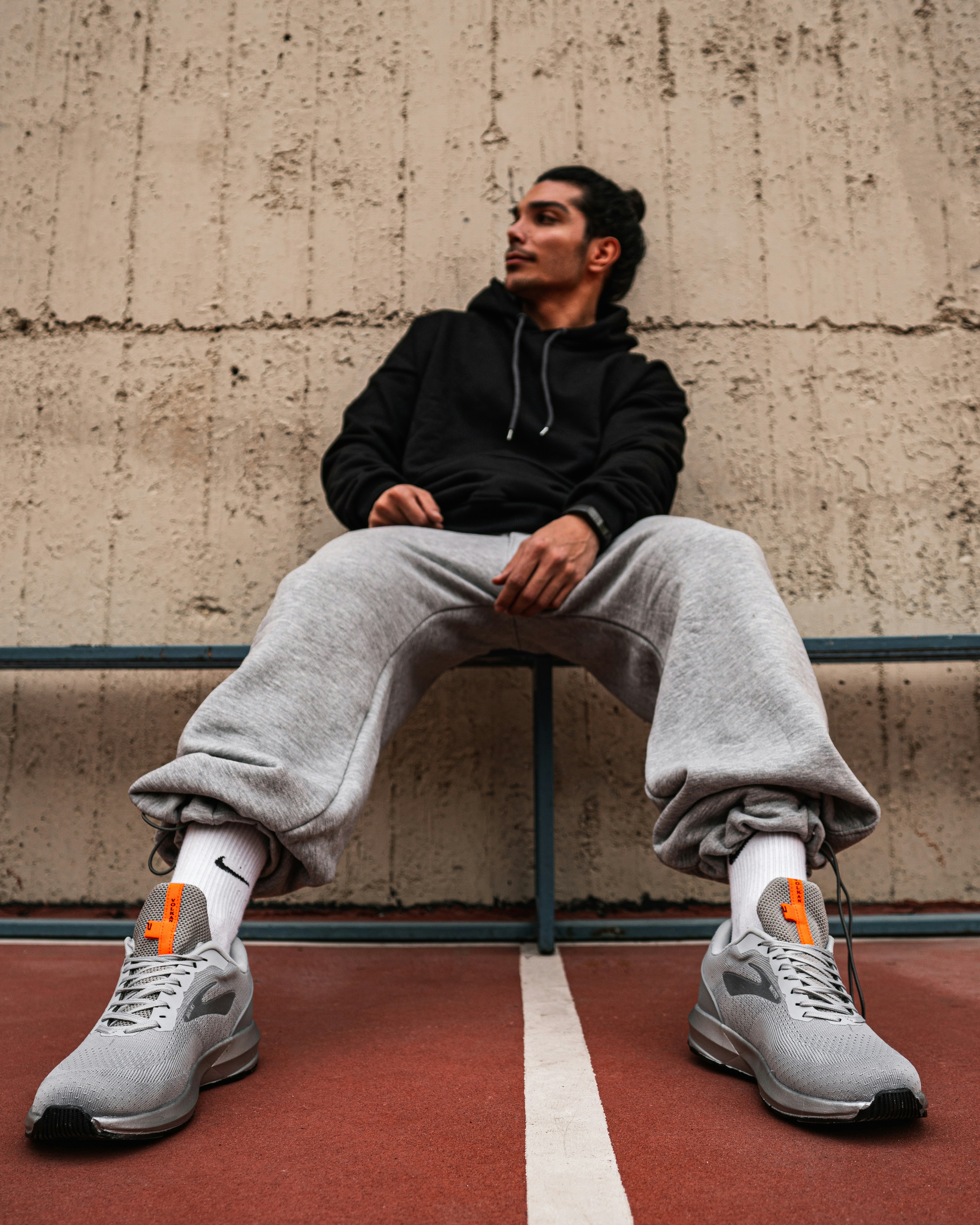 A man sitting on a bench with his legs crossed photo – Free Apparel ...