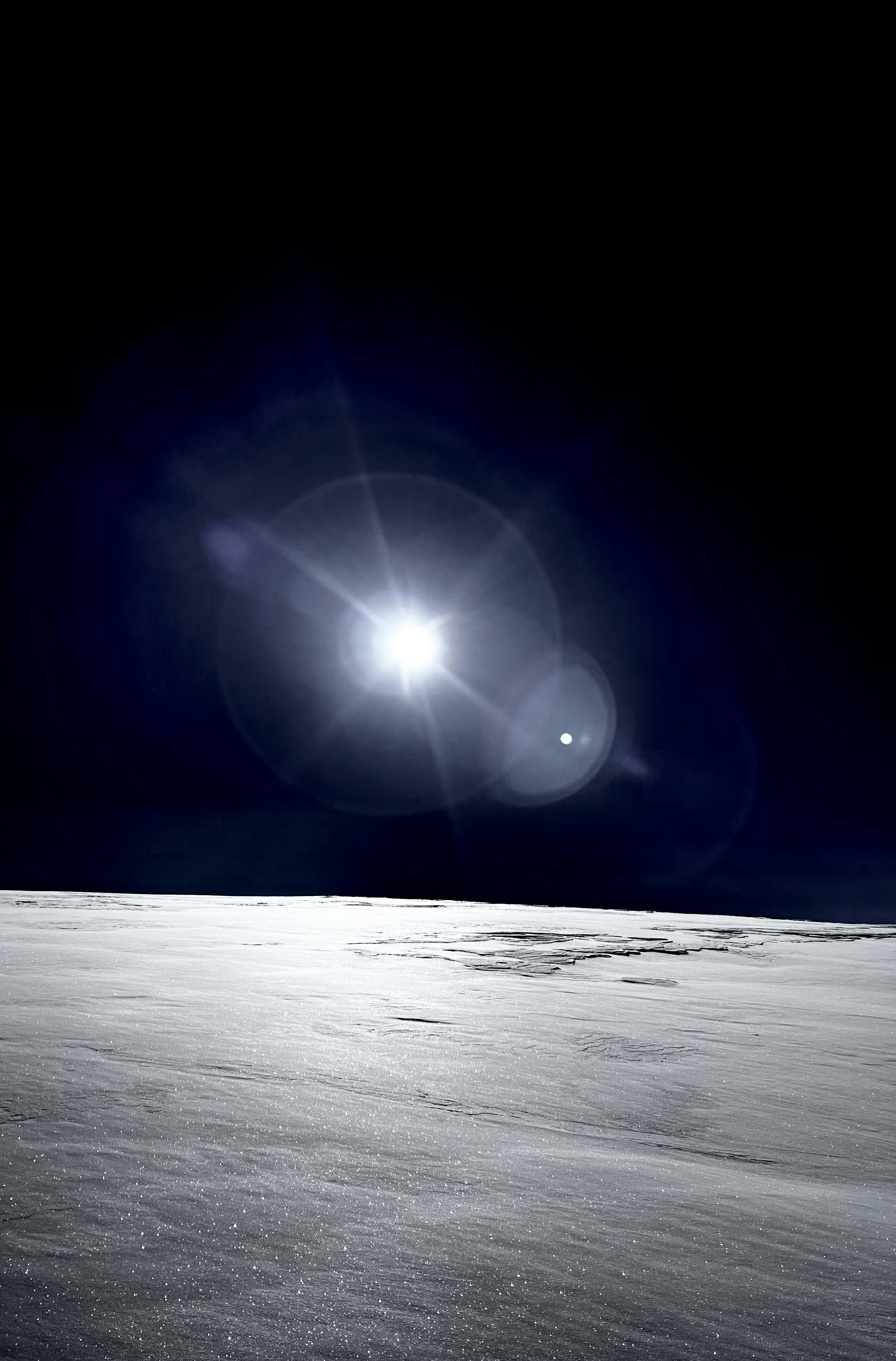 Halo over the Silent Snowfield: Night Sky and Sunflare on Ice