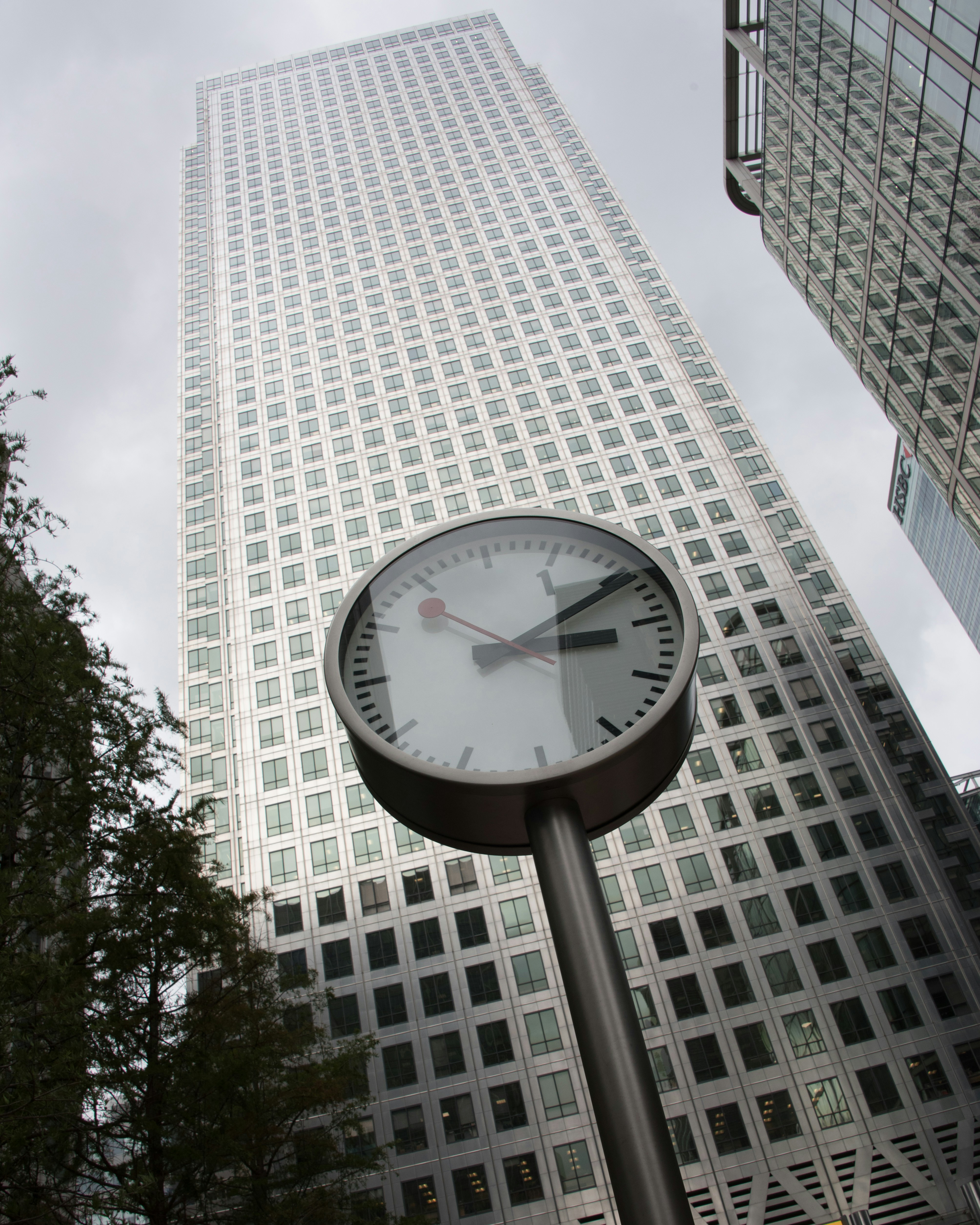 A clock on a pole in front of a tall building photo – Free Clock Image ...