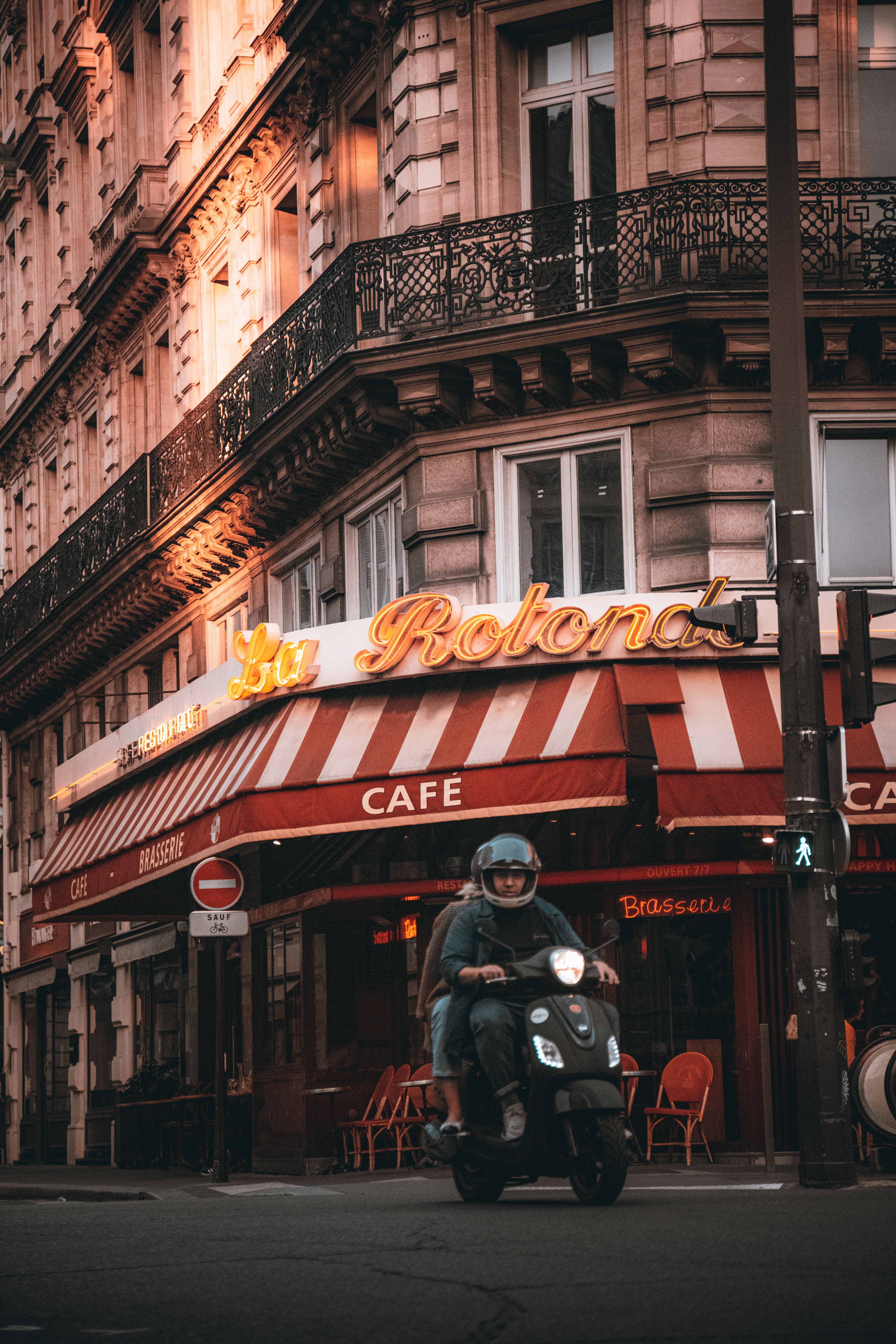 a man riding a motorcycle in front of a cafe