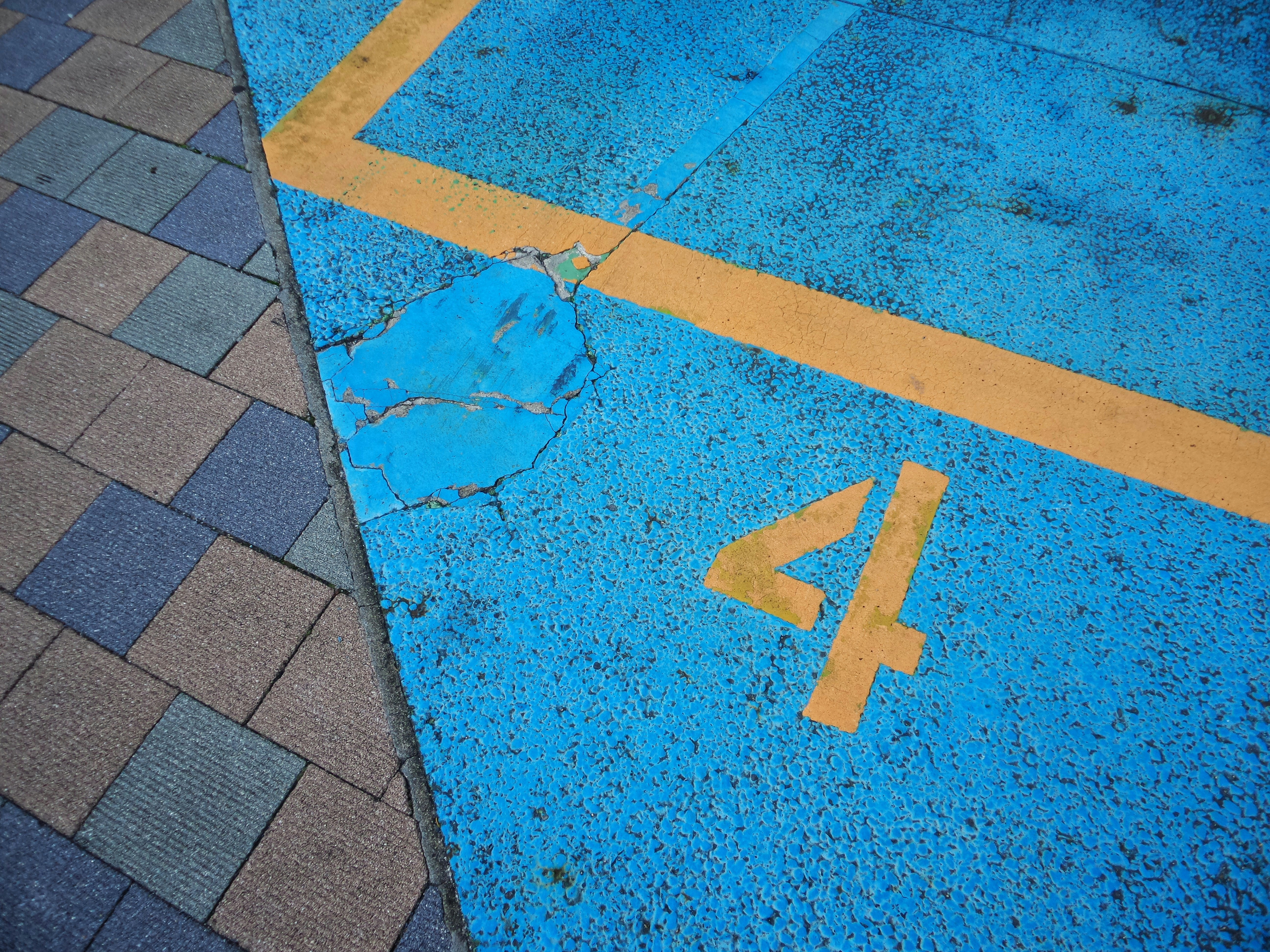 A blue parking lot with a yellow line painted on it photo – Free Floor ...