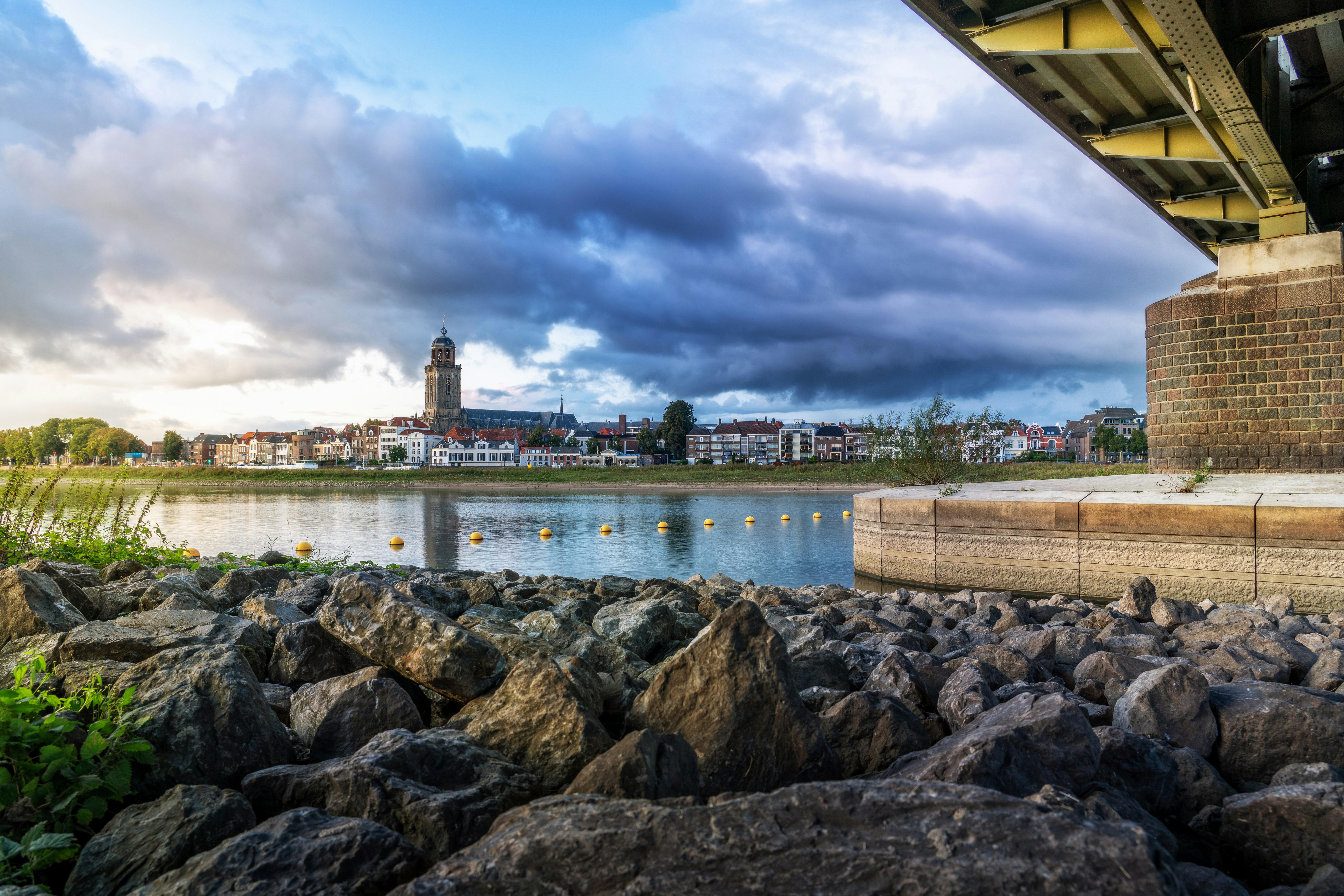 Cloudscape of Deventer taken from the riverside with rocks in front