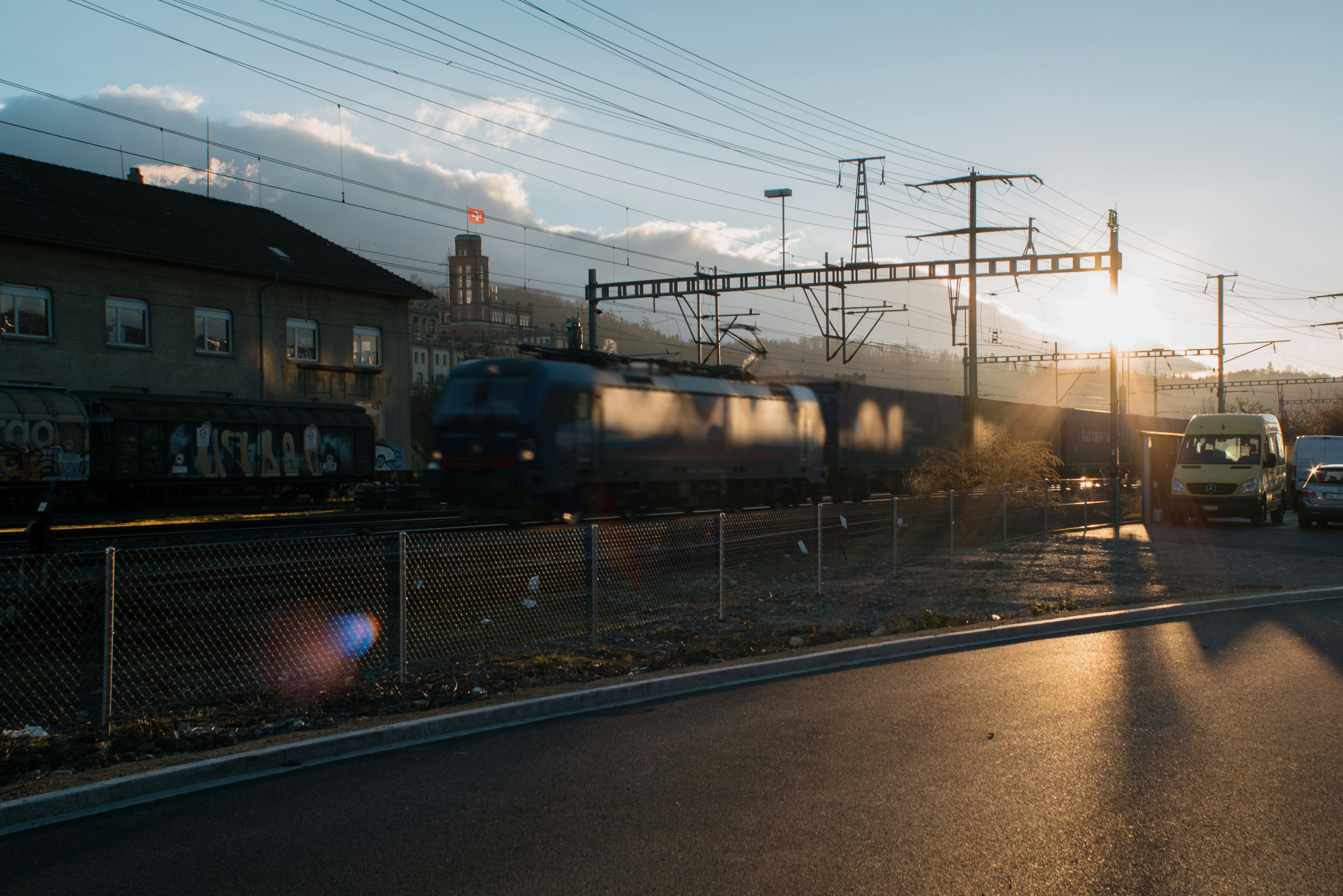 Un tren que viaja por las vías del tren junto a una valla foto – Imagen ...