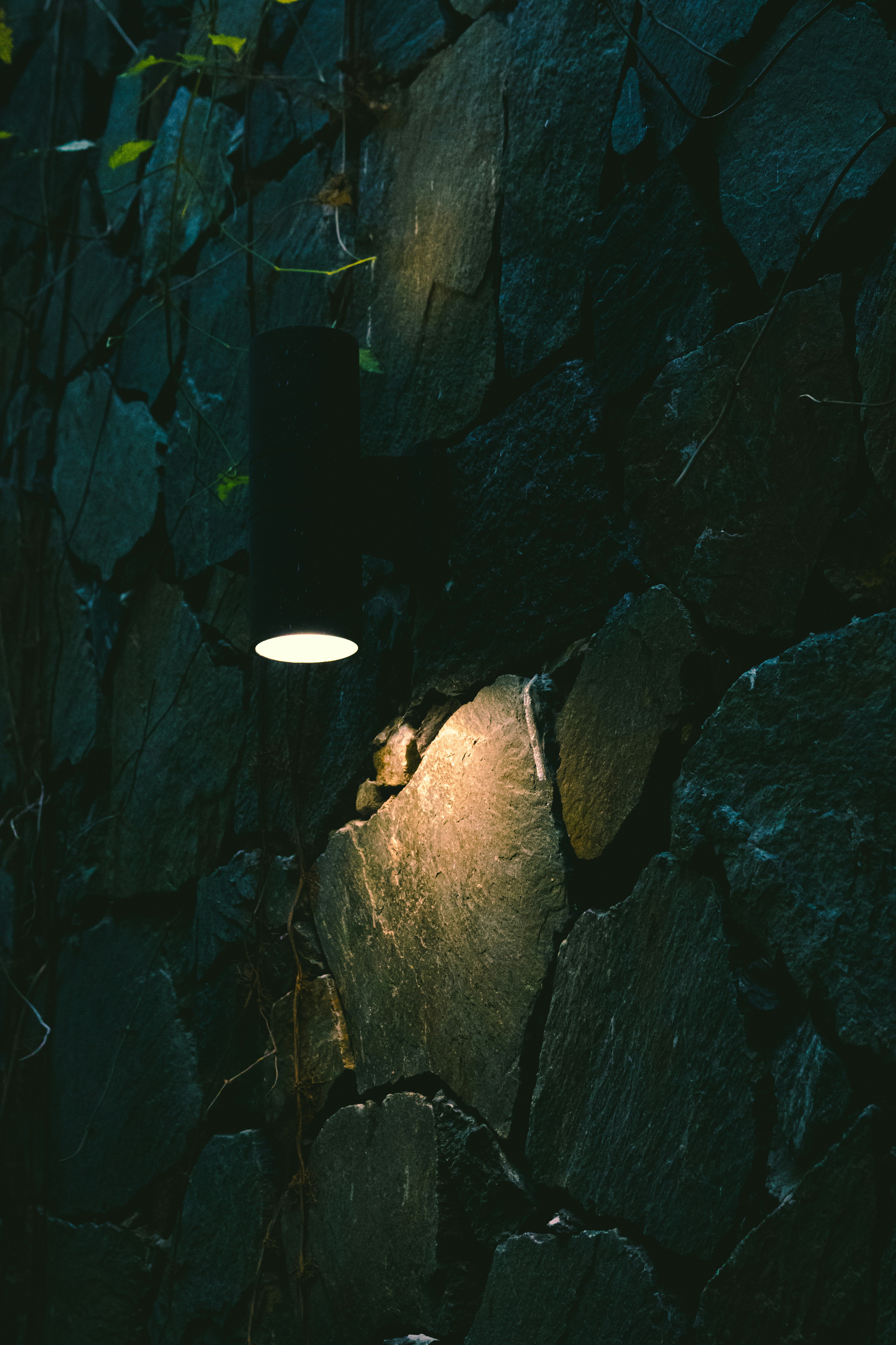 A Lone Cylinder Lantern Casts a Golden Beam Across Damp Stonework.
