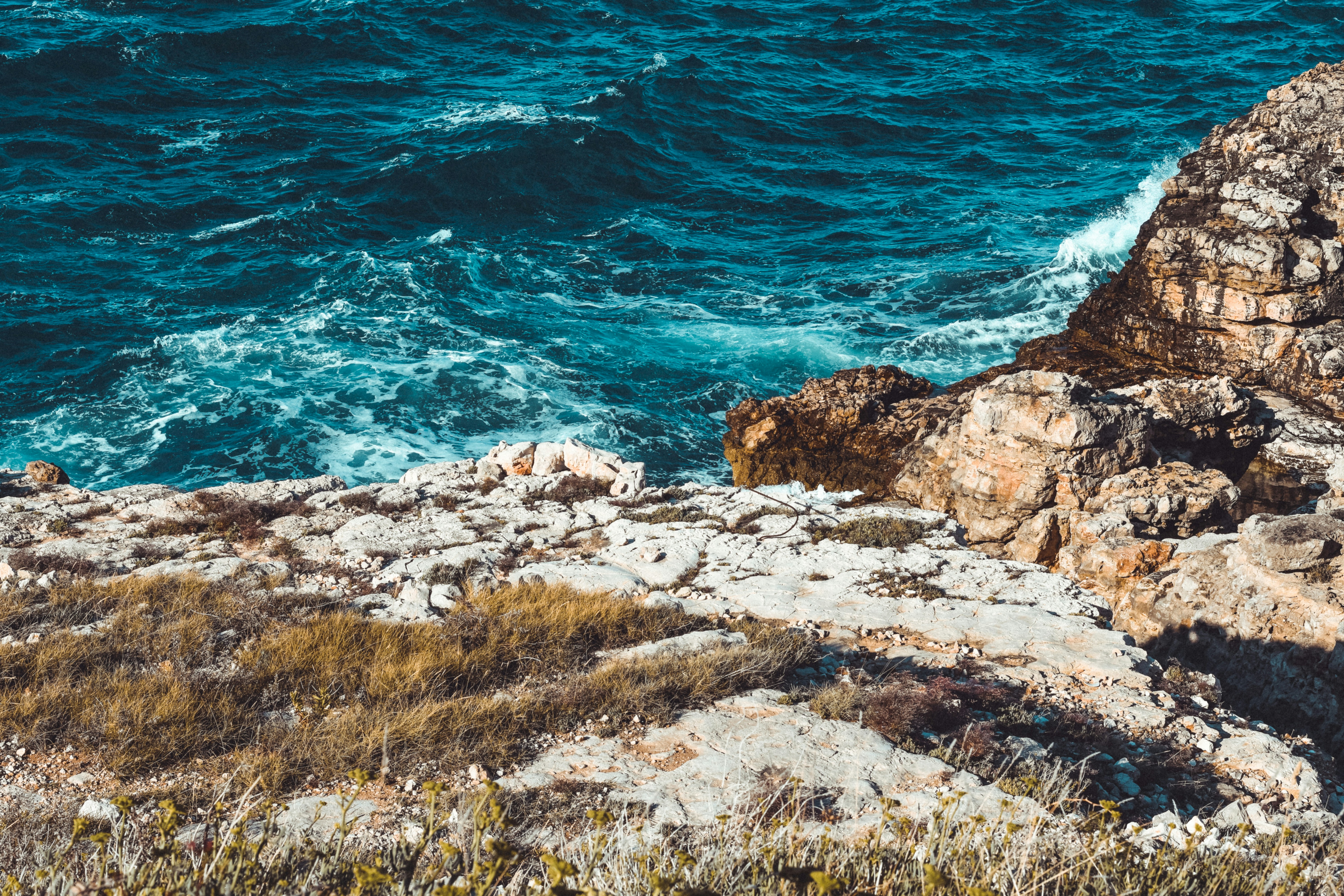 Foto Un acantilado rocoso con un cuerpo de agua en el fondo – Imagen ...