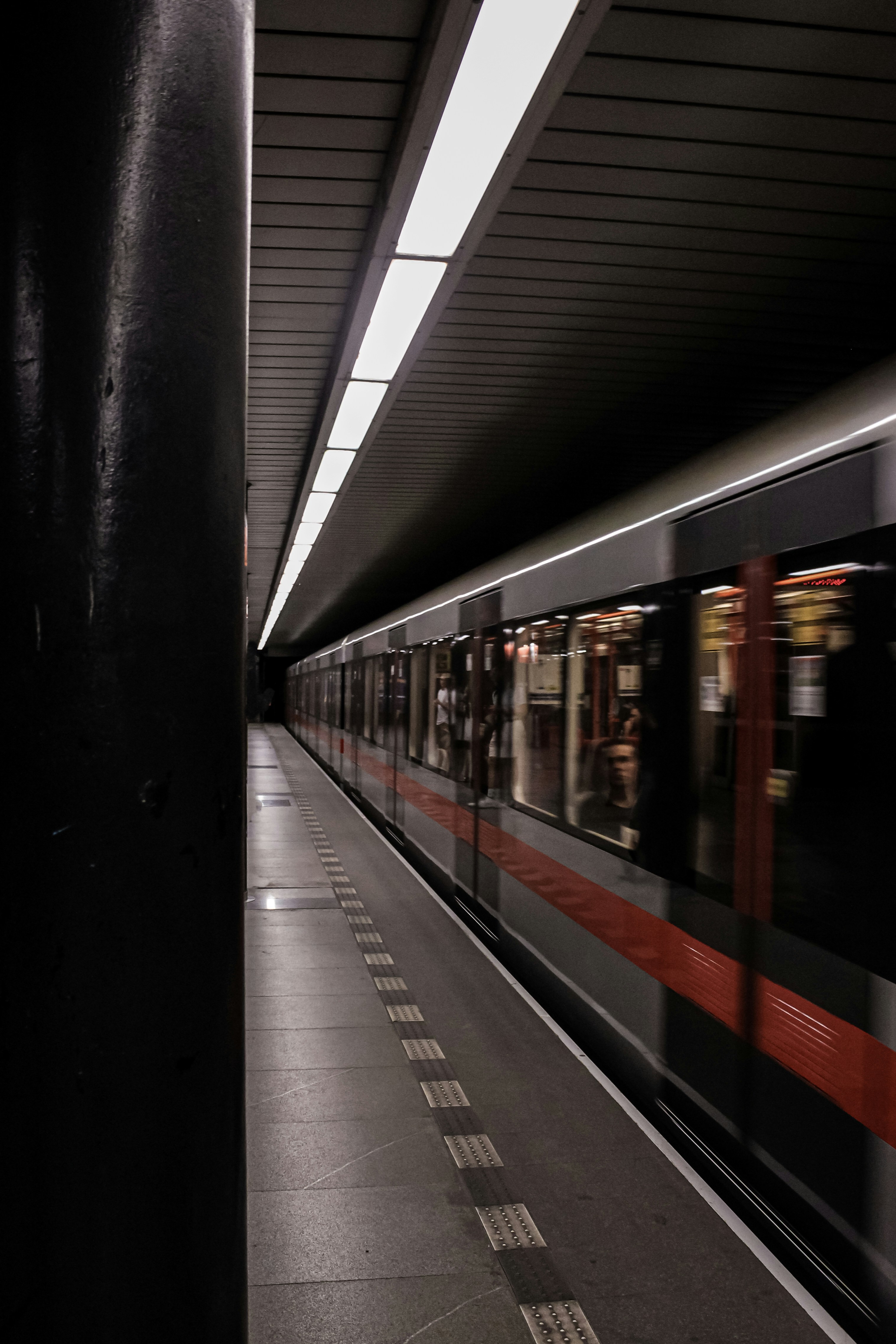 A subway train speeds past a dimly lit platform, showcasing the dynamic energy of urban commuting.