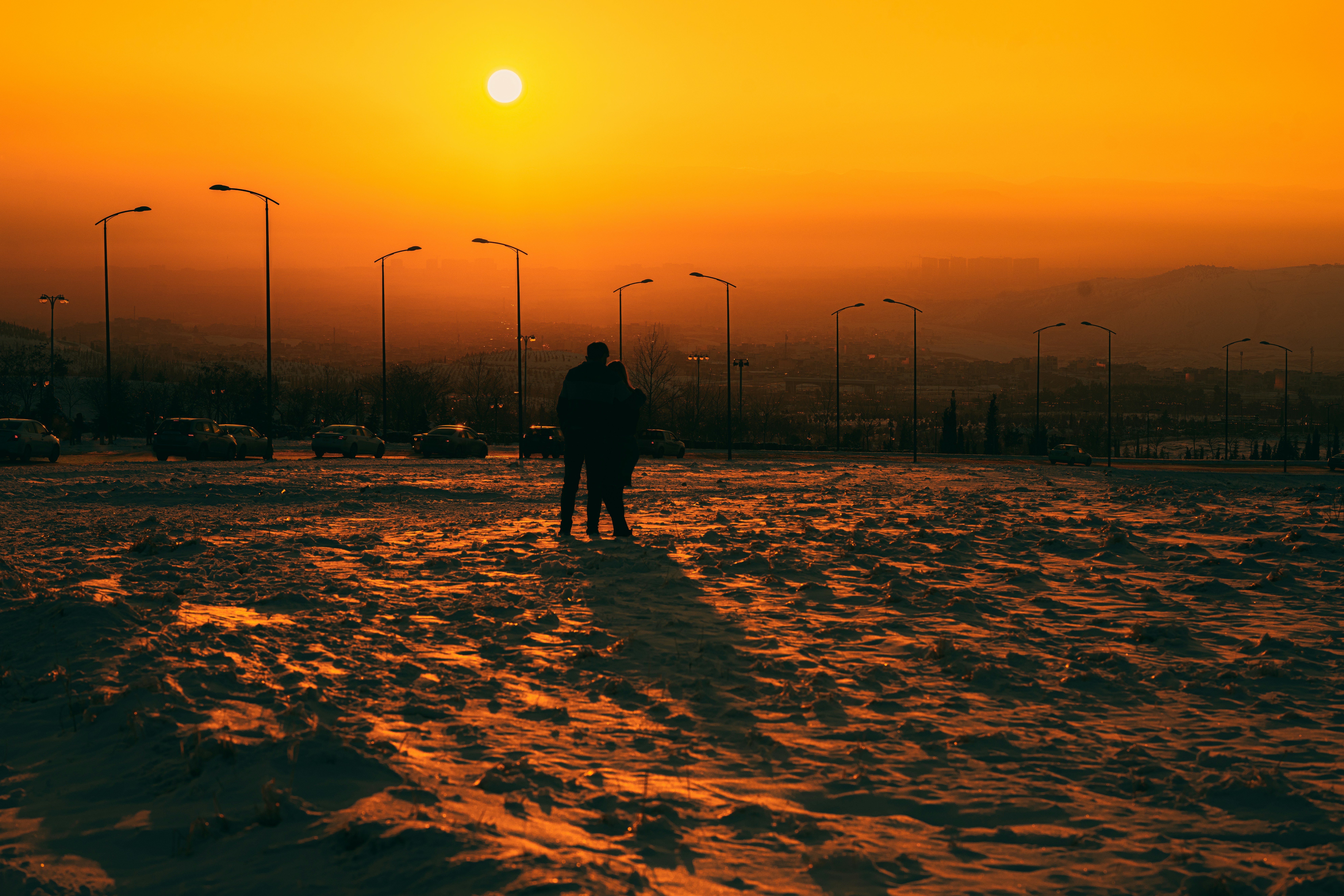 Dusk Embrace: Silhouette in a Snow-Lit Parking Lot