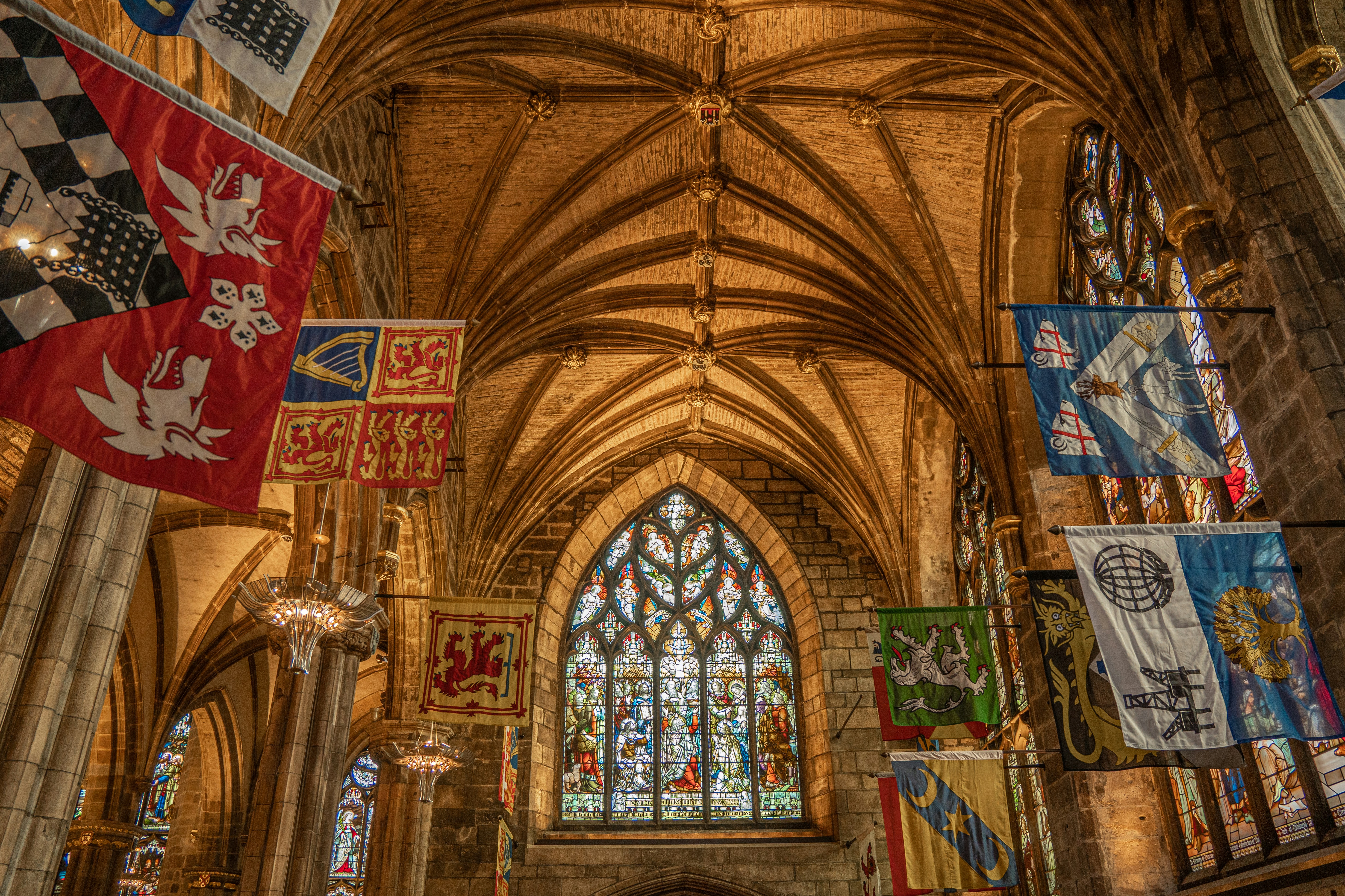 A large cathedral with flags hanging from the ceiling photo – Free ...