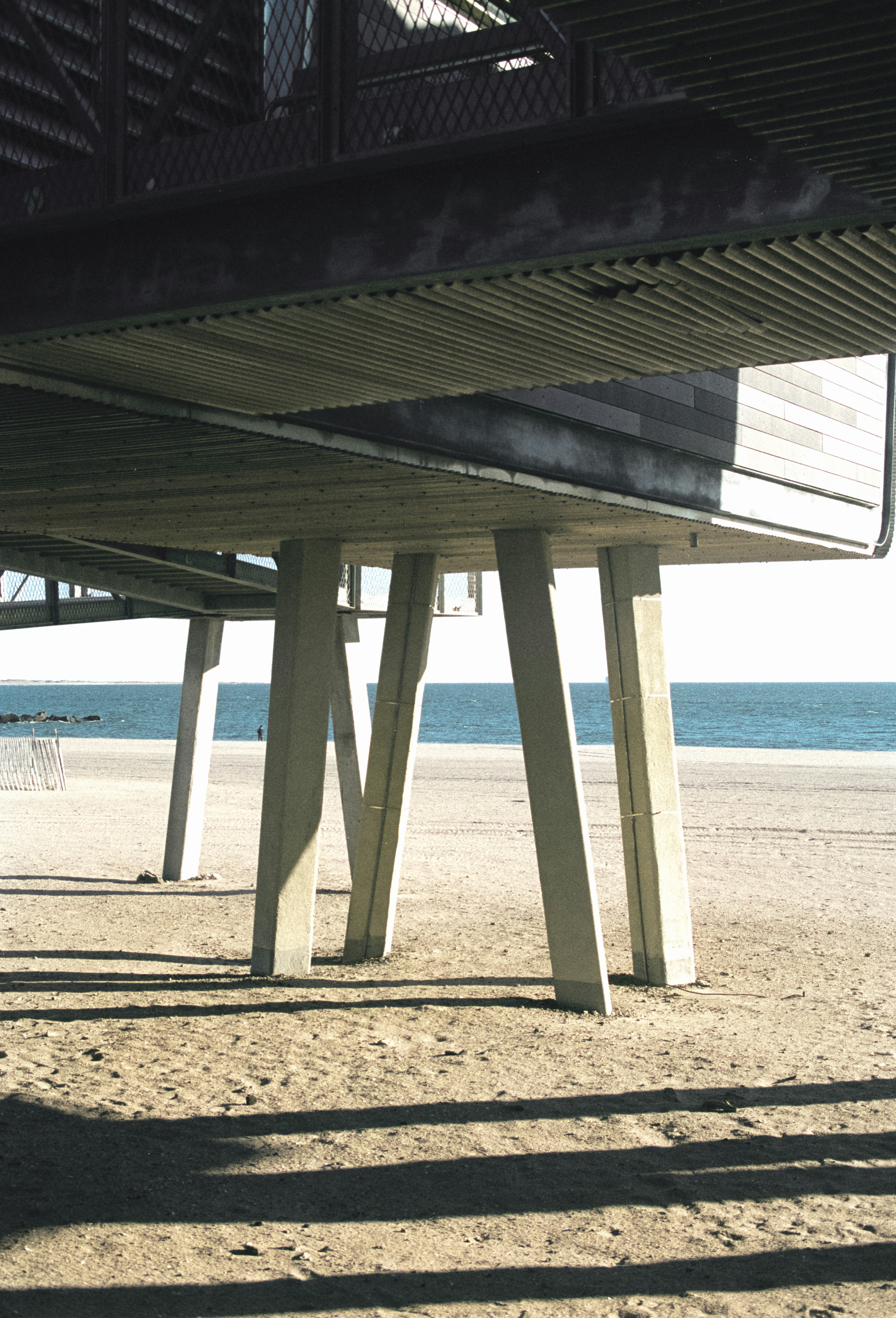 A view of a beach from underneath a pier photo – Free Film photography ...
