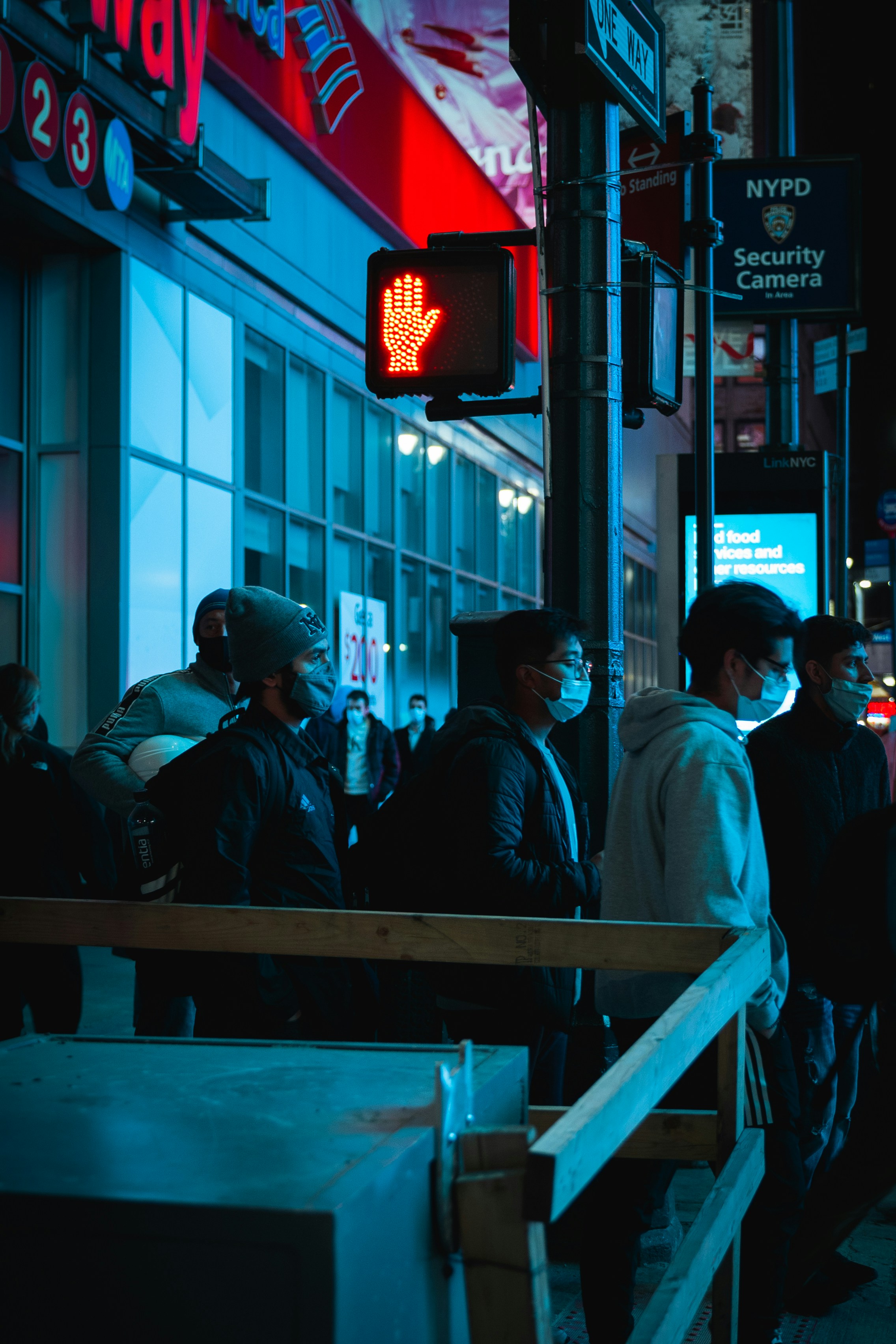 Red Hand at the Neon Crosswalk: Masked Pedestrians under Blue Manhattan Glow