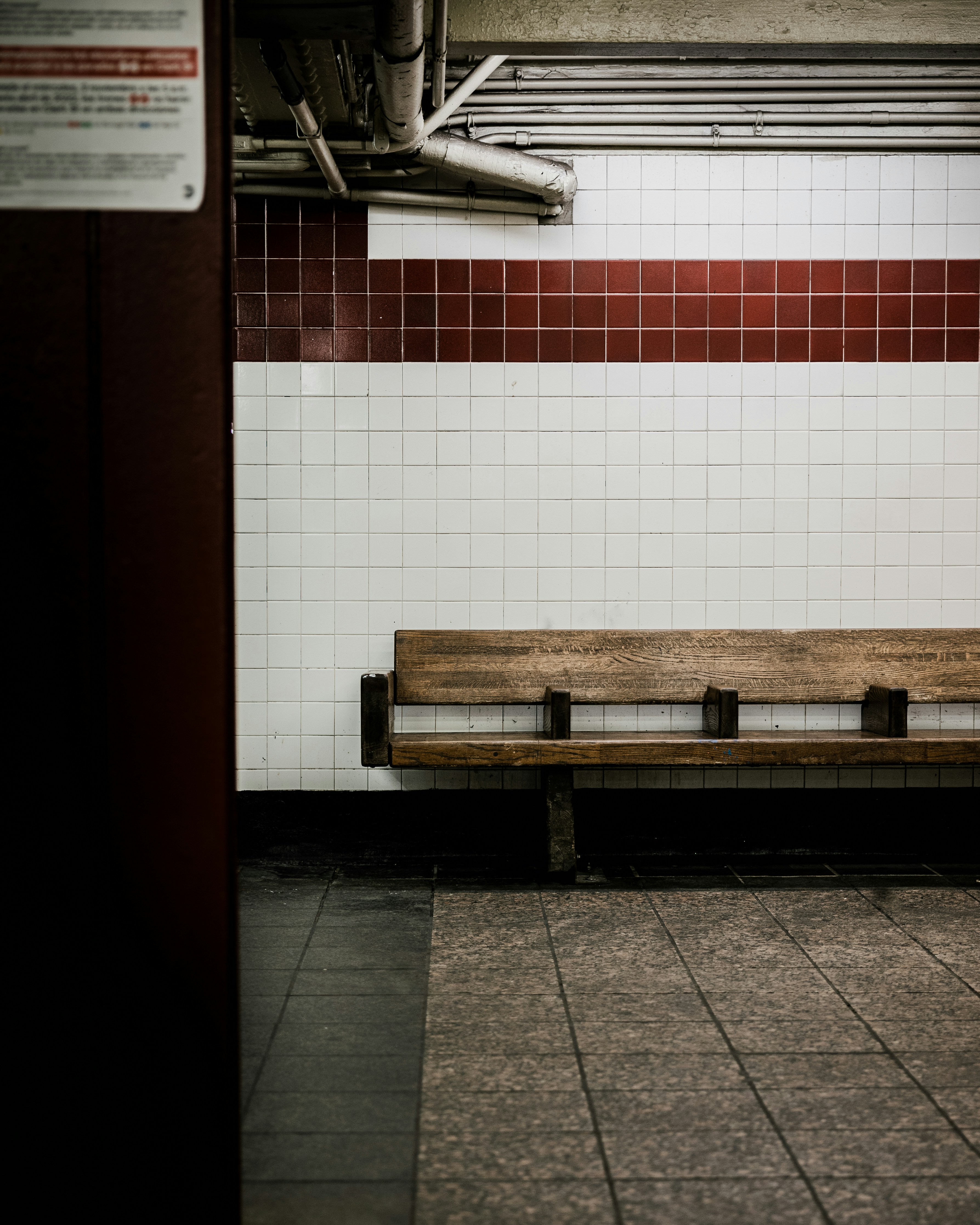 A wooden bench sitting in a subway station photo – Free Train Image on ...