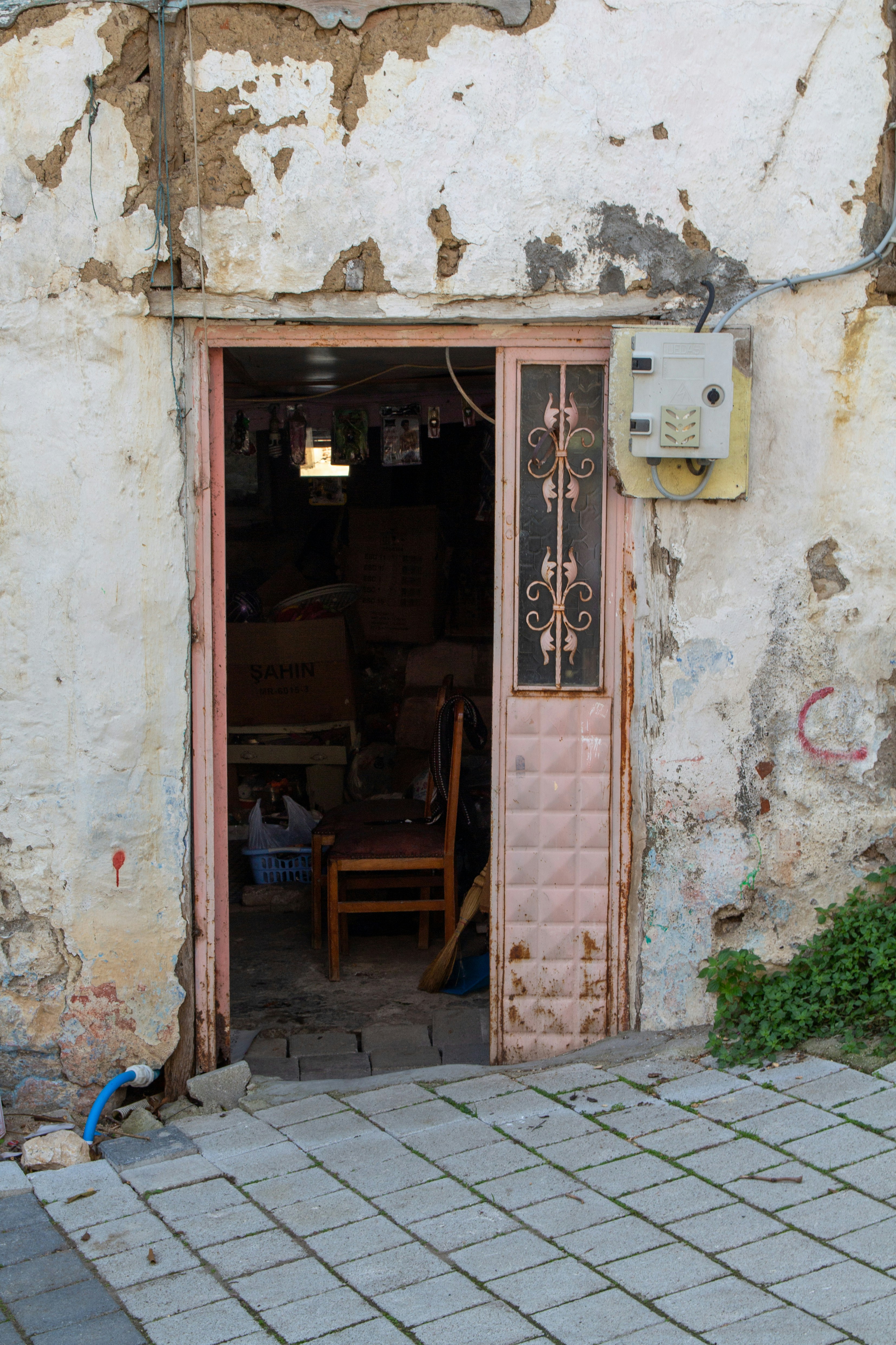 Pastel Portal: A Timeworn Façade Revealing a Cluttered Interior