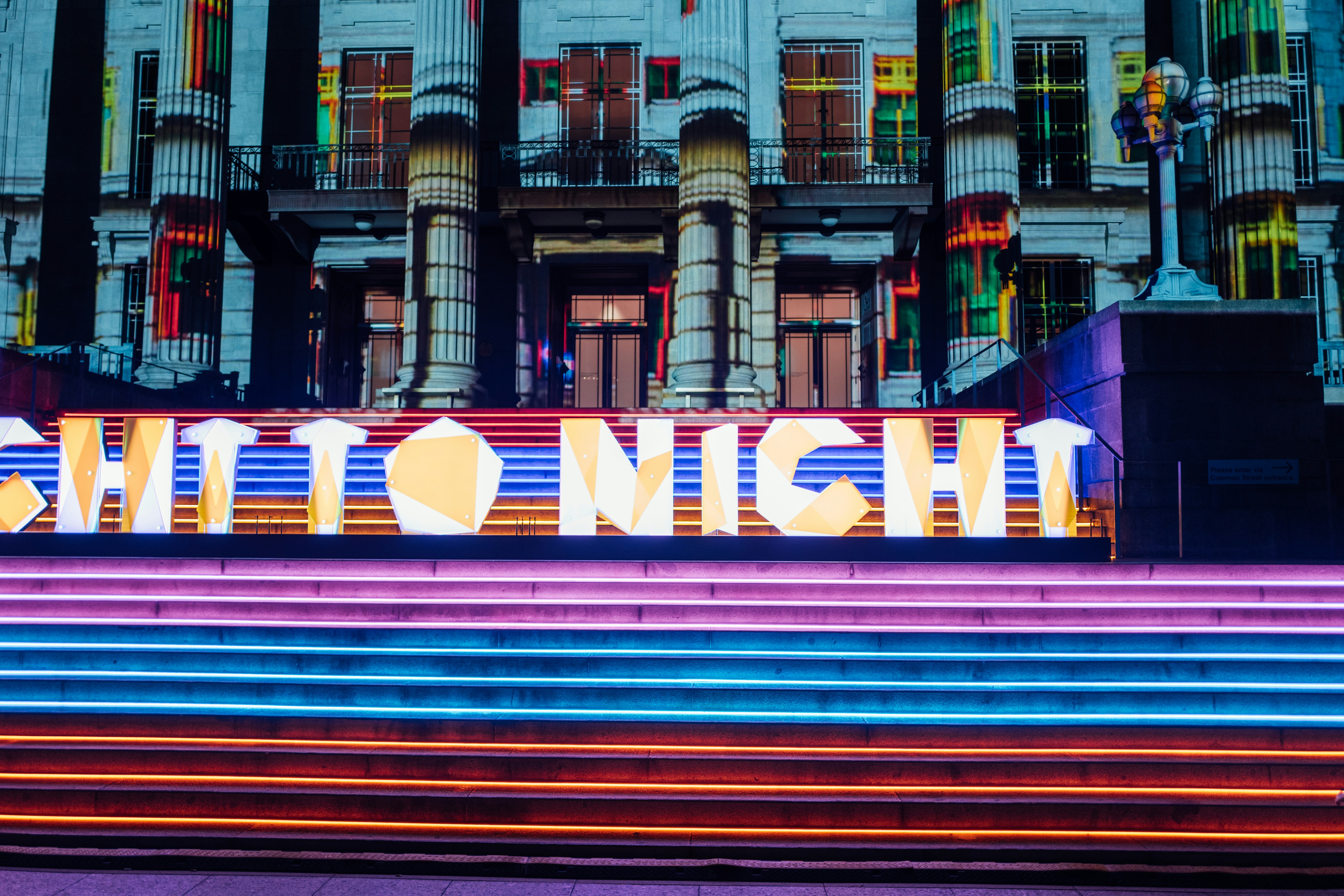 Chromatic Neon Steps Beneath a Classical Facade