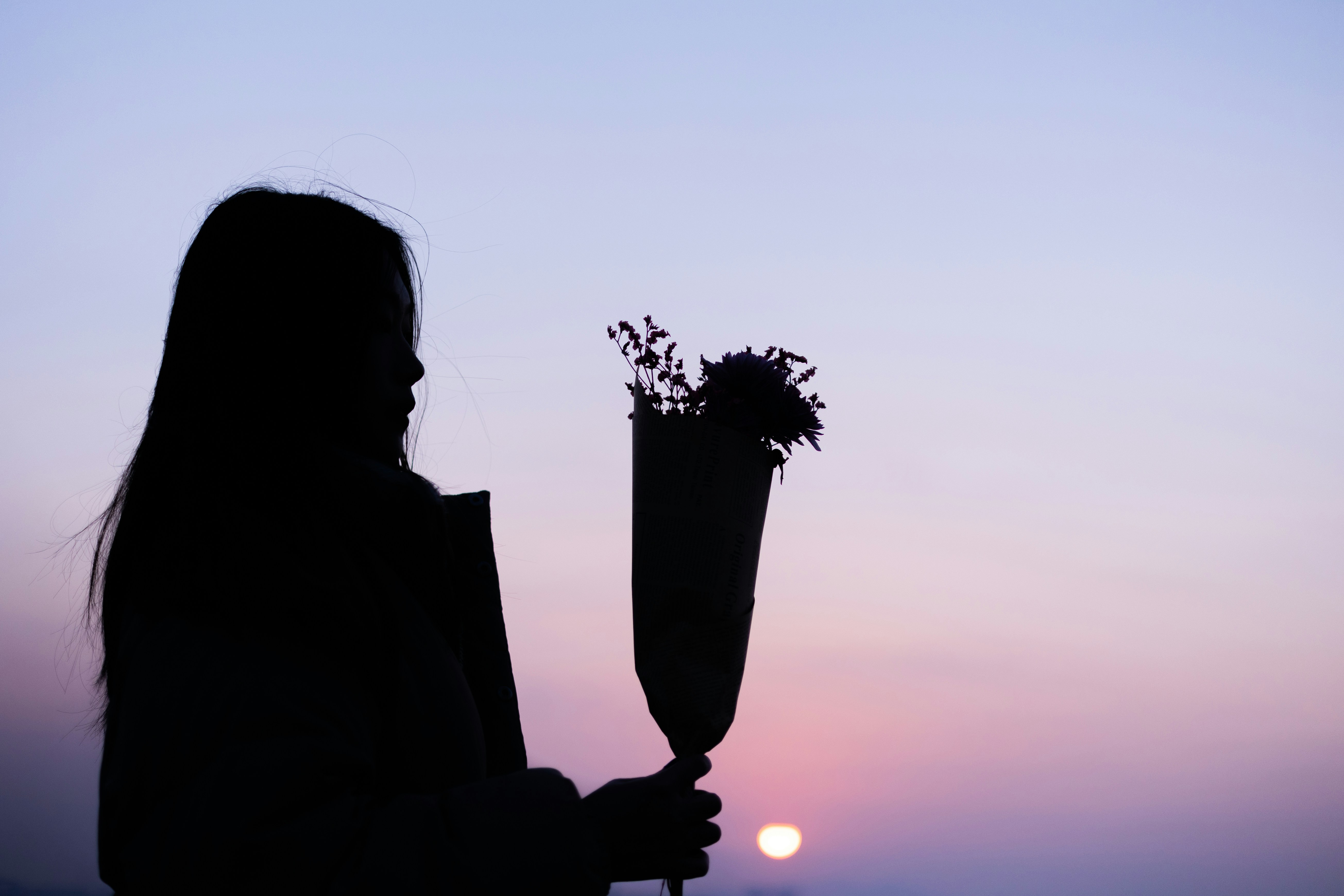Dusk Silhouette: A Figure Cradling a Bouquet Against a Velvet Horizon