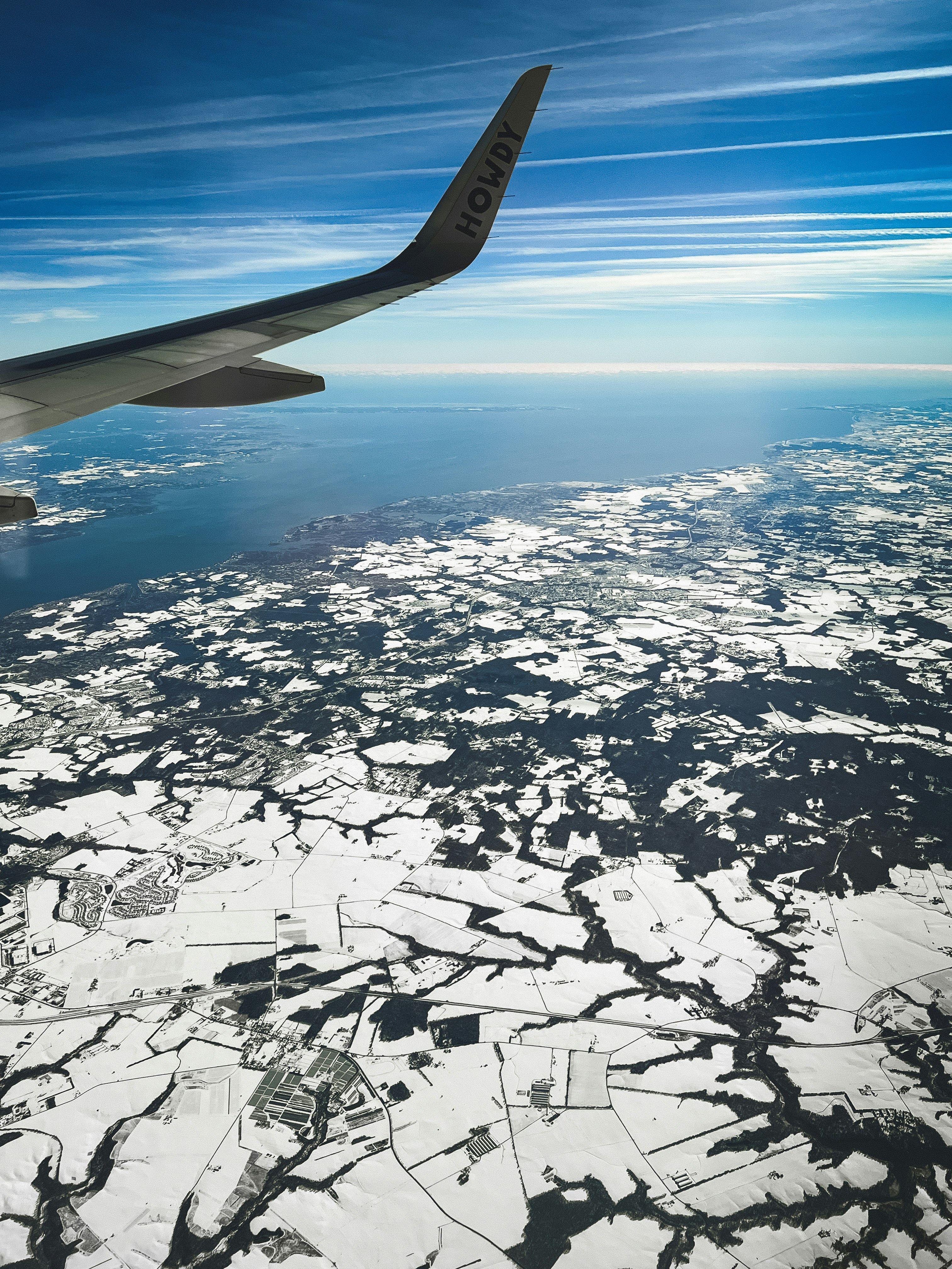 Wingtip Panorama: Snow-Grid Fields Meet the Distant Sea