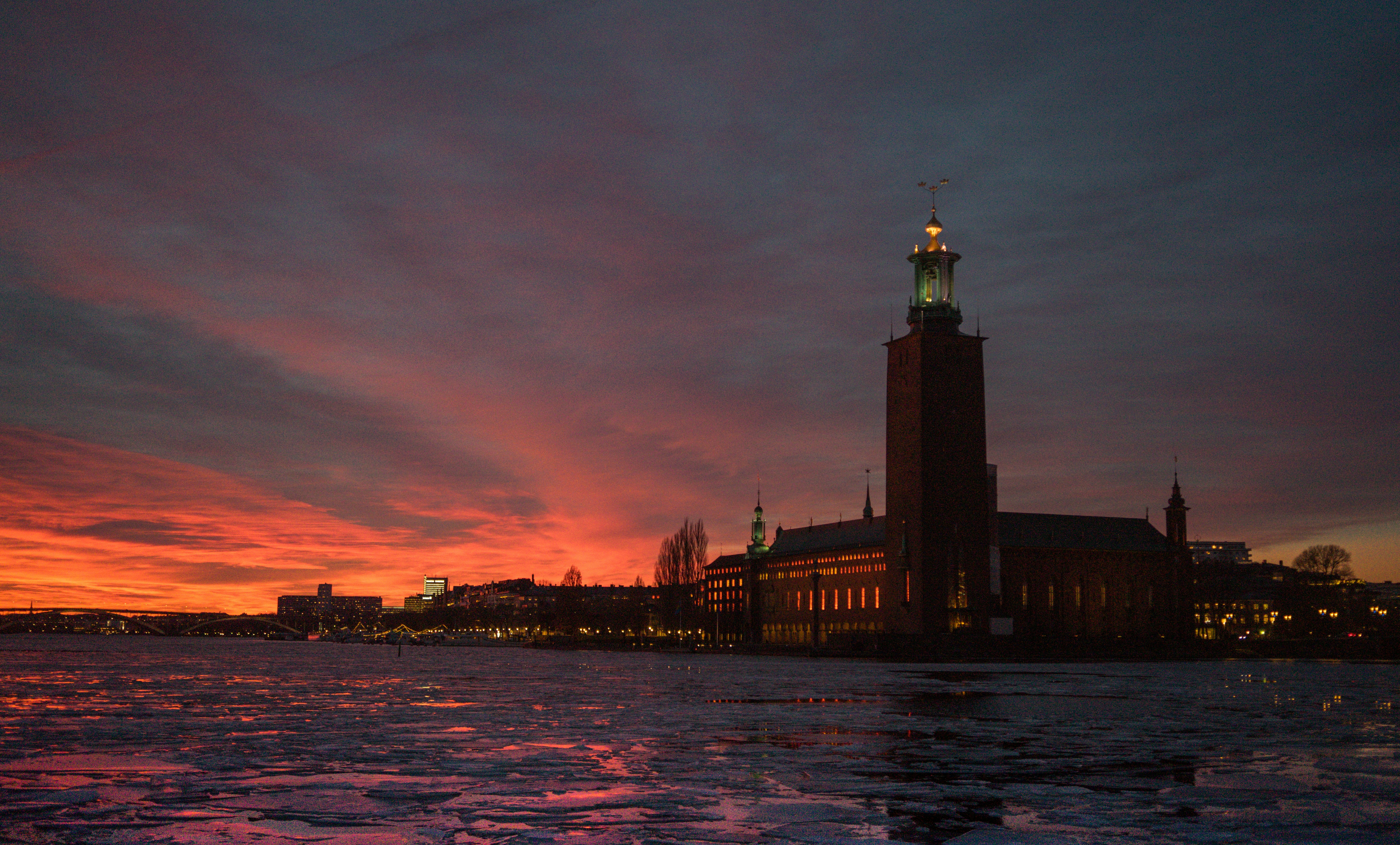 A large clock tower towering over a body of water photo – Free ...