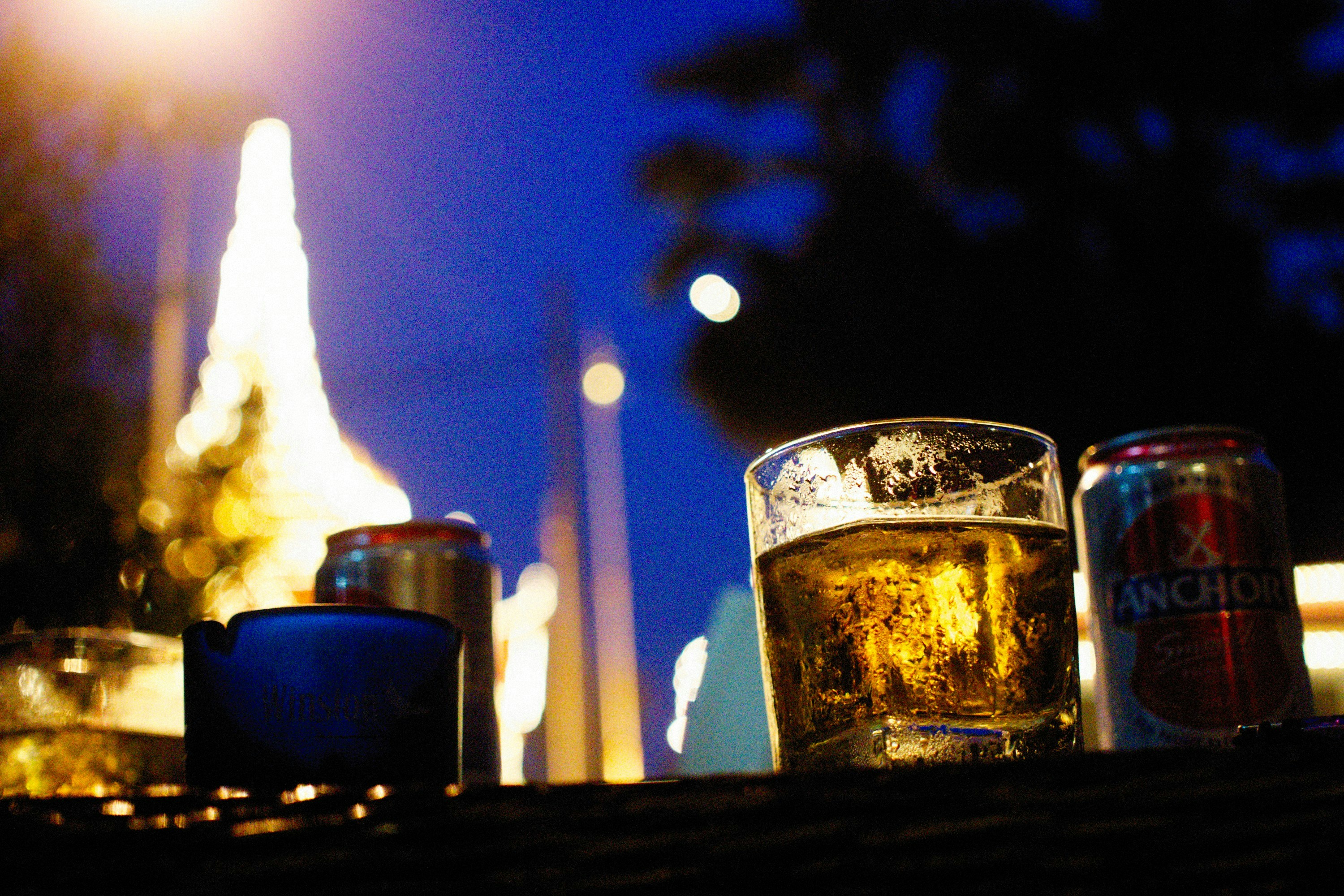 a glass of beer sitting on top of a wooden table