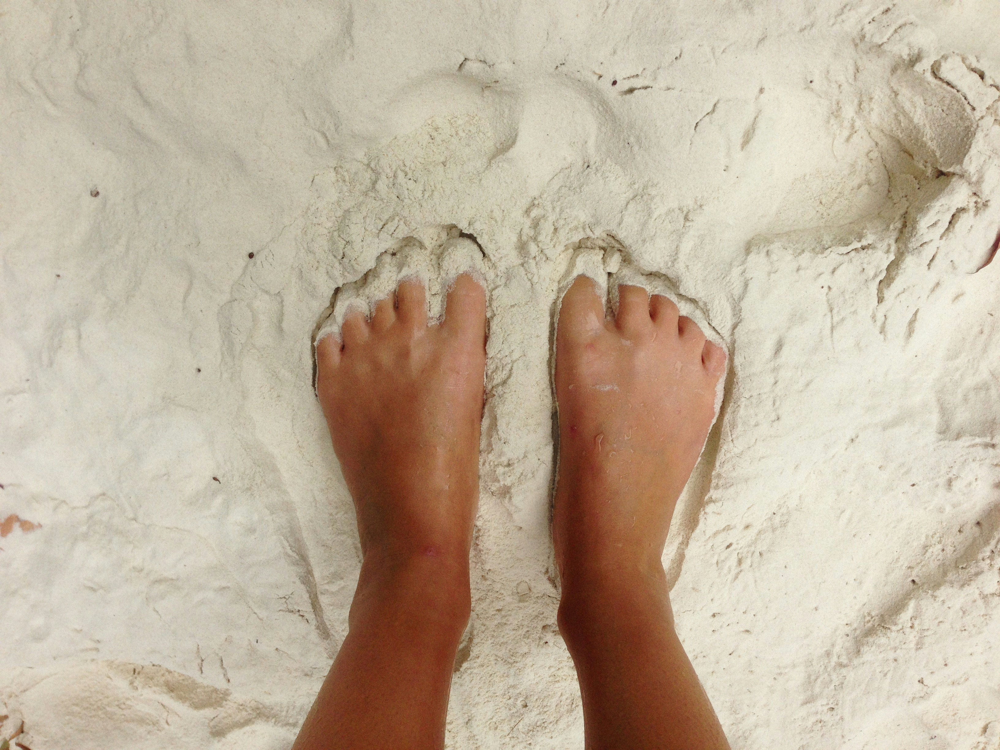 Barefoot on sun-warmed sand: twin impressions at the edge of the sea