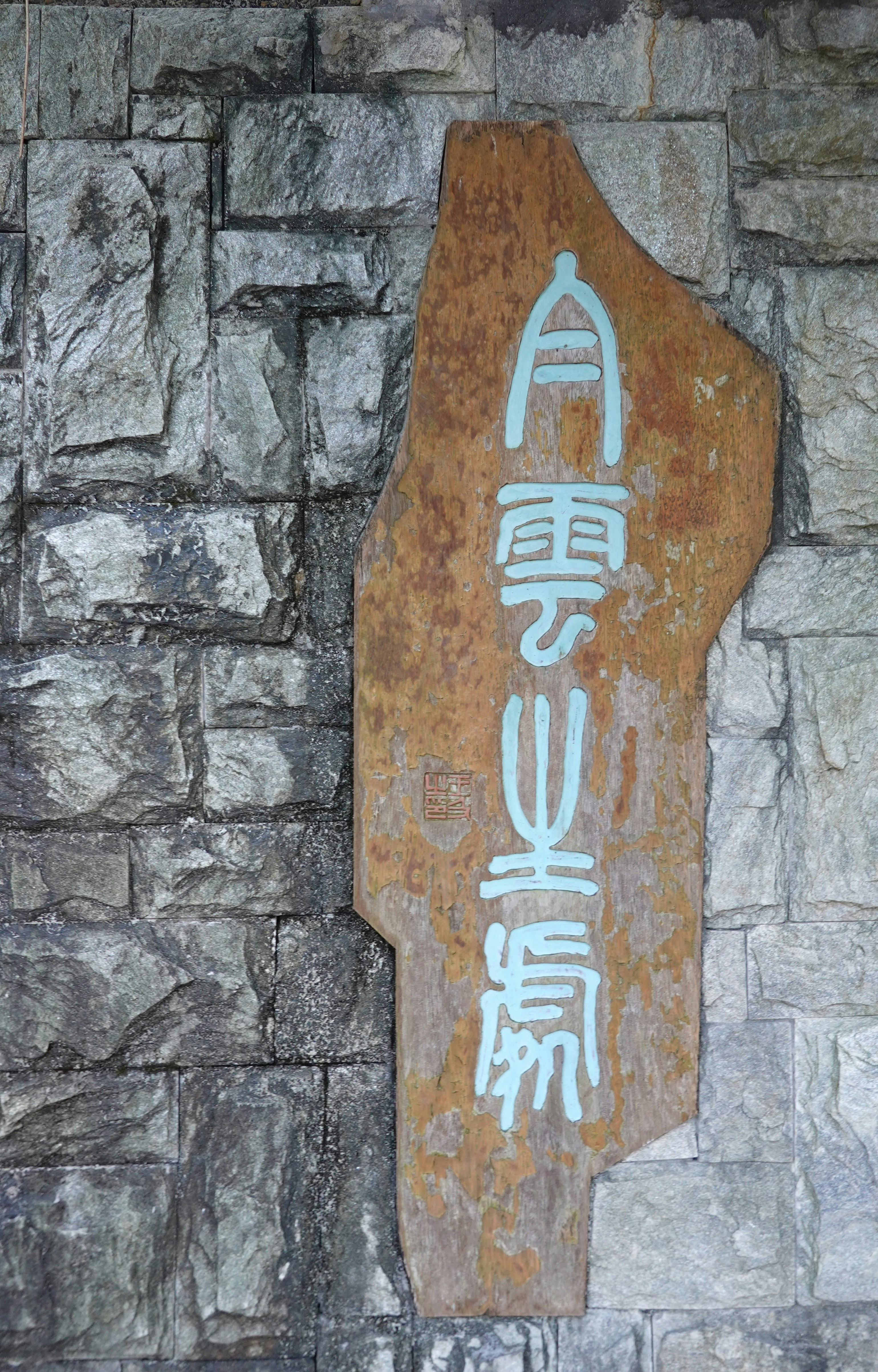 a stone wall with a sign on it