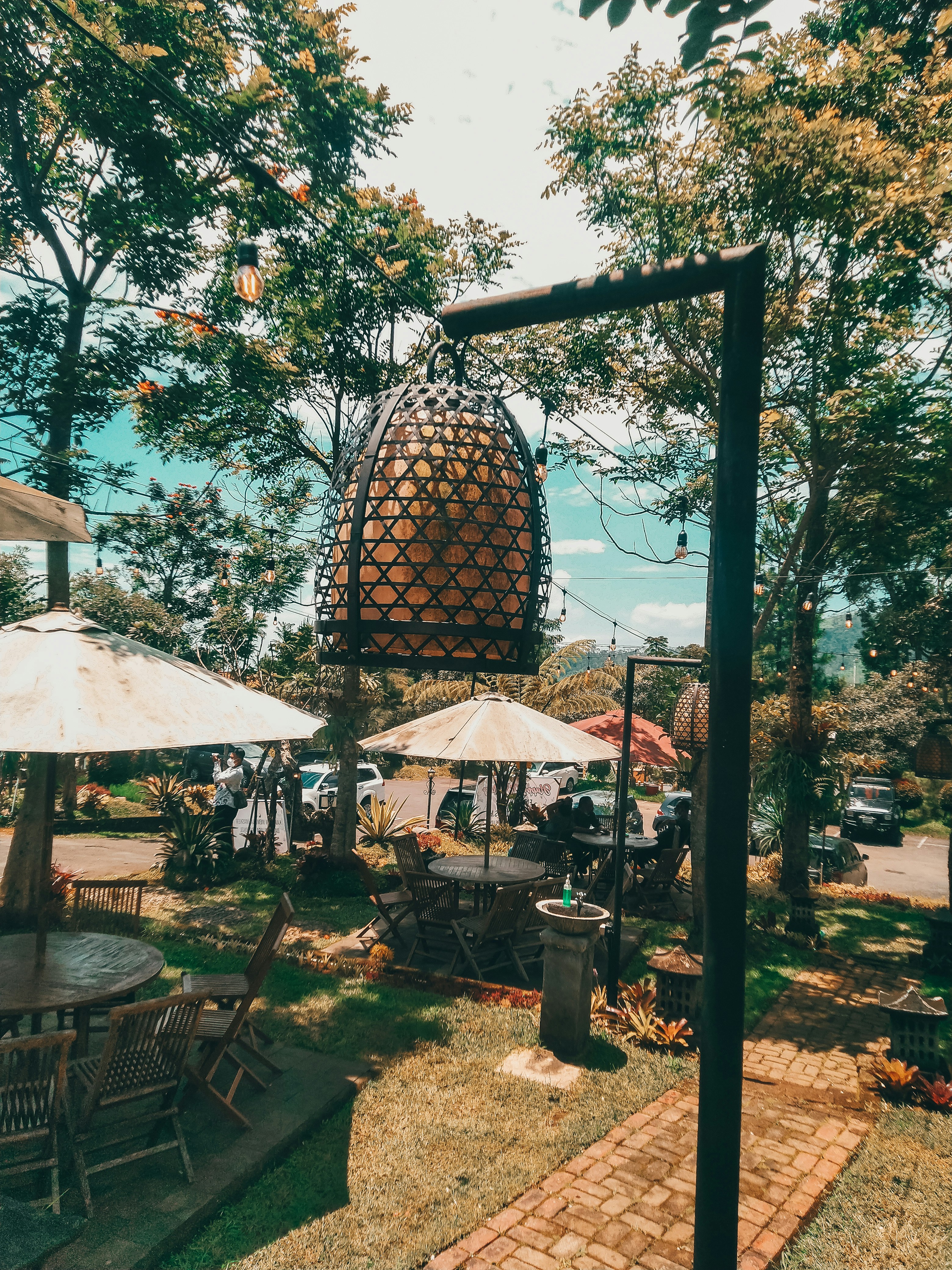 Hanging Lantern Over a Sunlit Café Courtyard