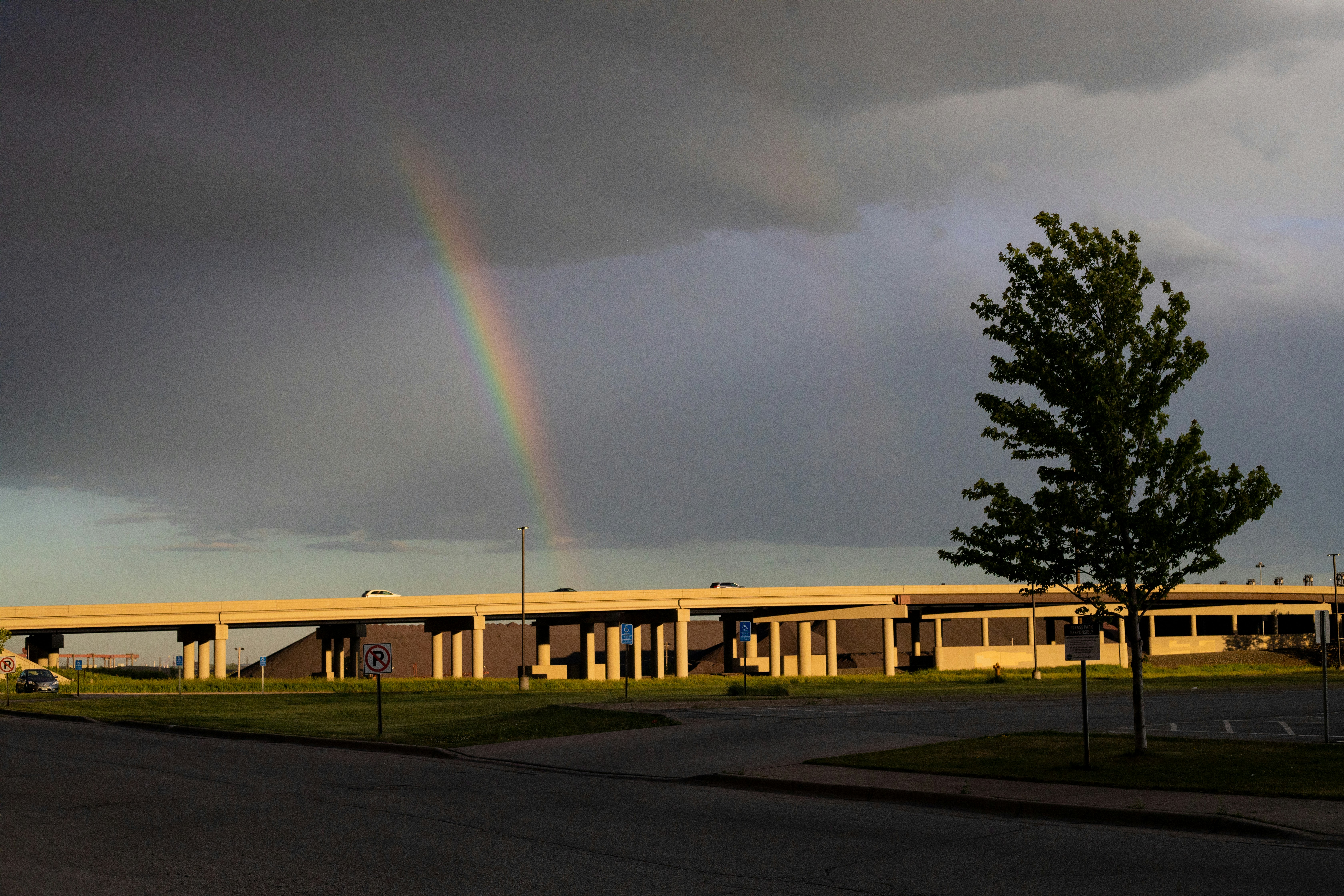 Ribbon in the Rain: Rainbow Arch Above the Suburban Overpass