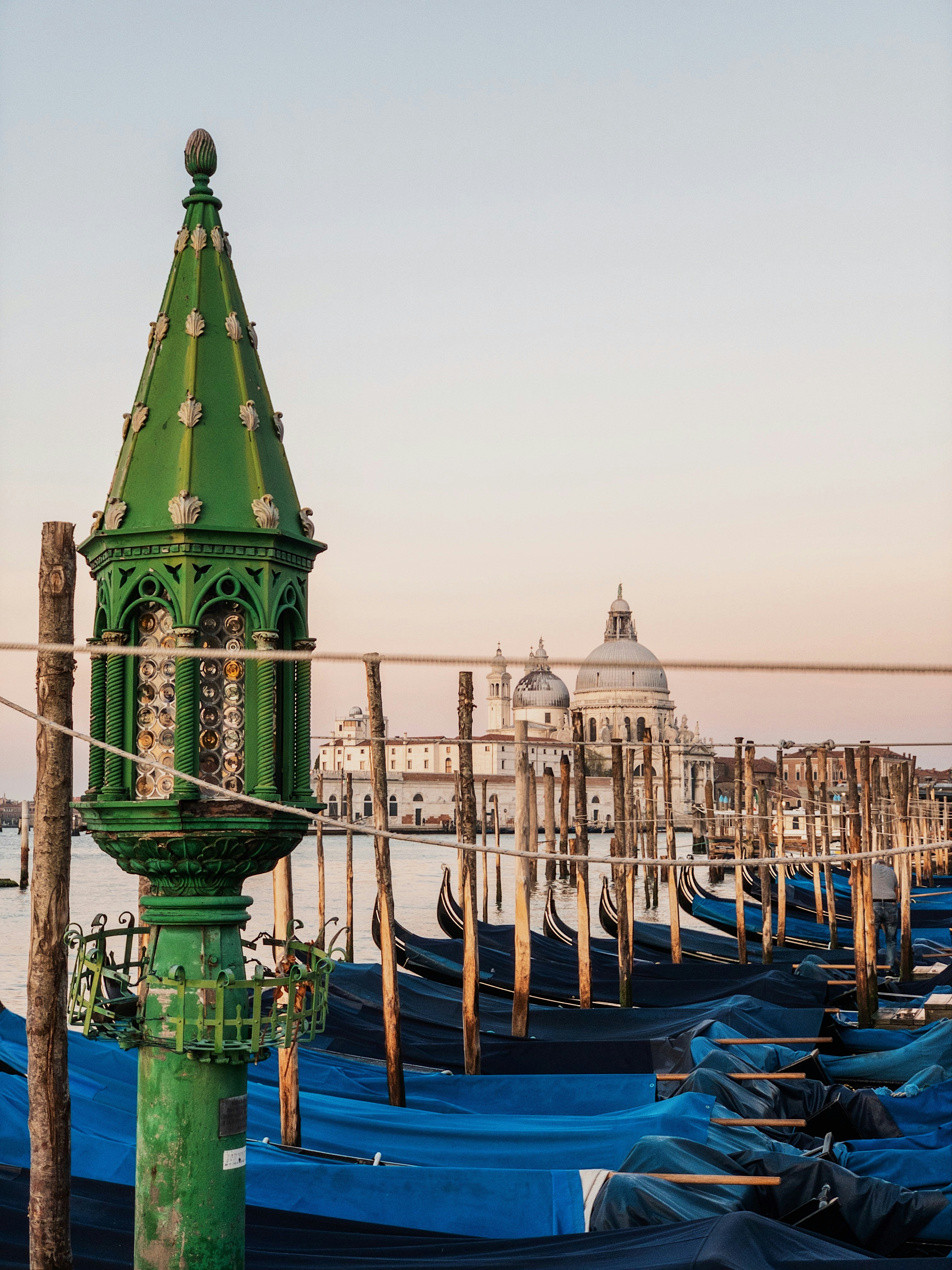 A green clock tower in the middle of a dock photo – Free Building Image ...