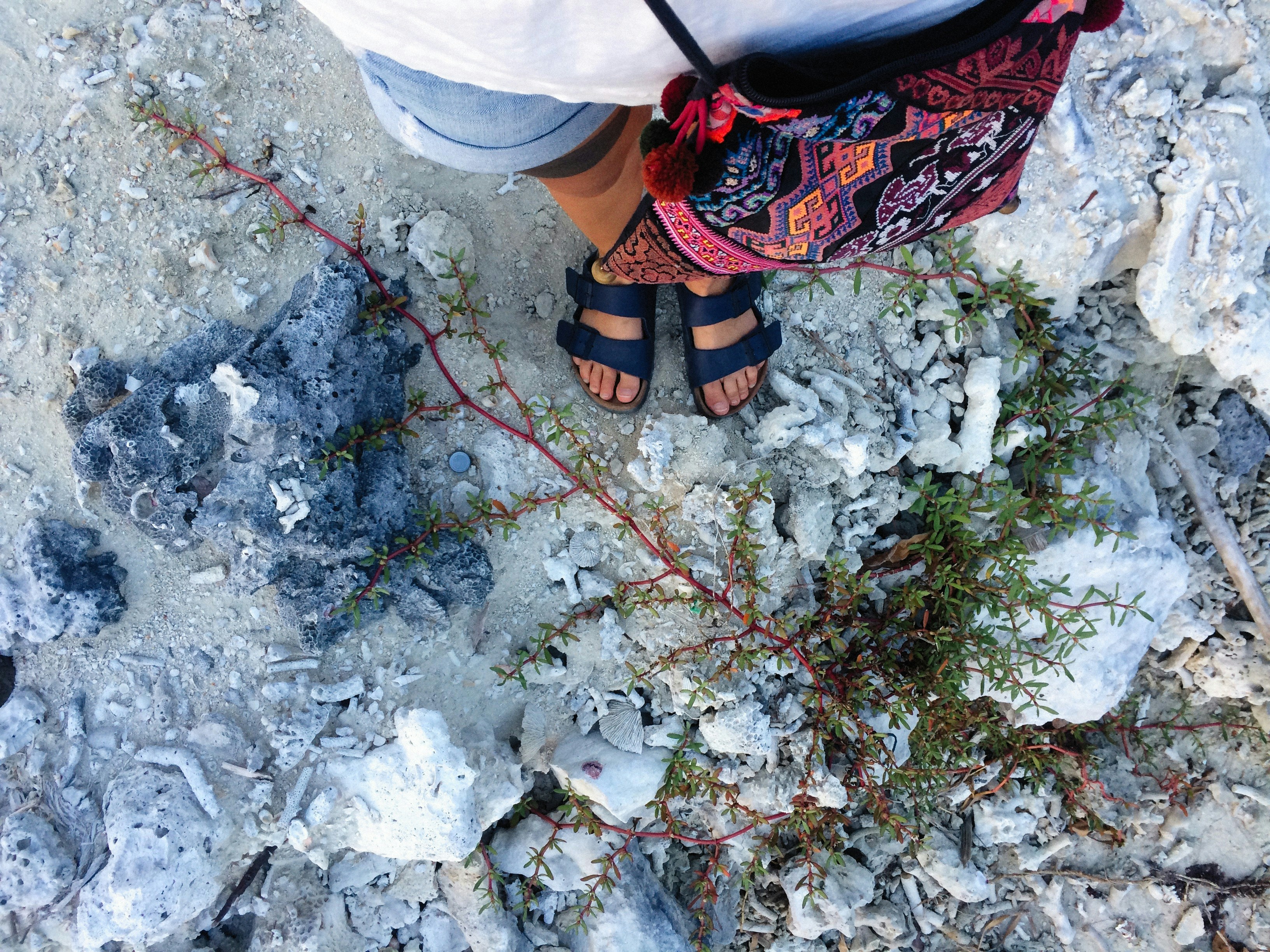 Top-Down Trek: Sandals on a Craggy Ridge with a Patterned Satchel