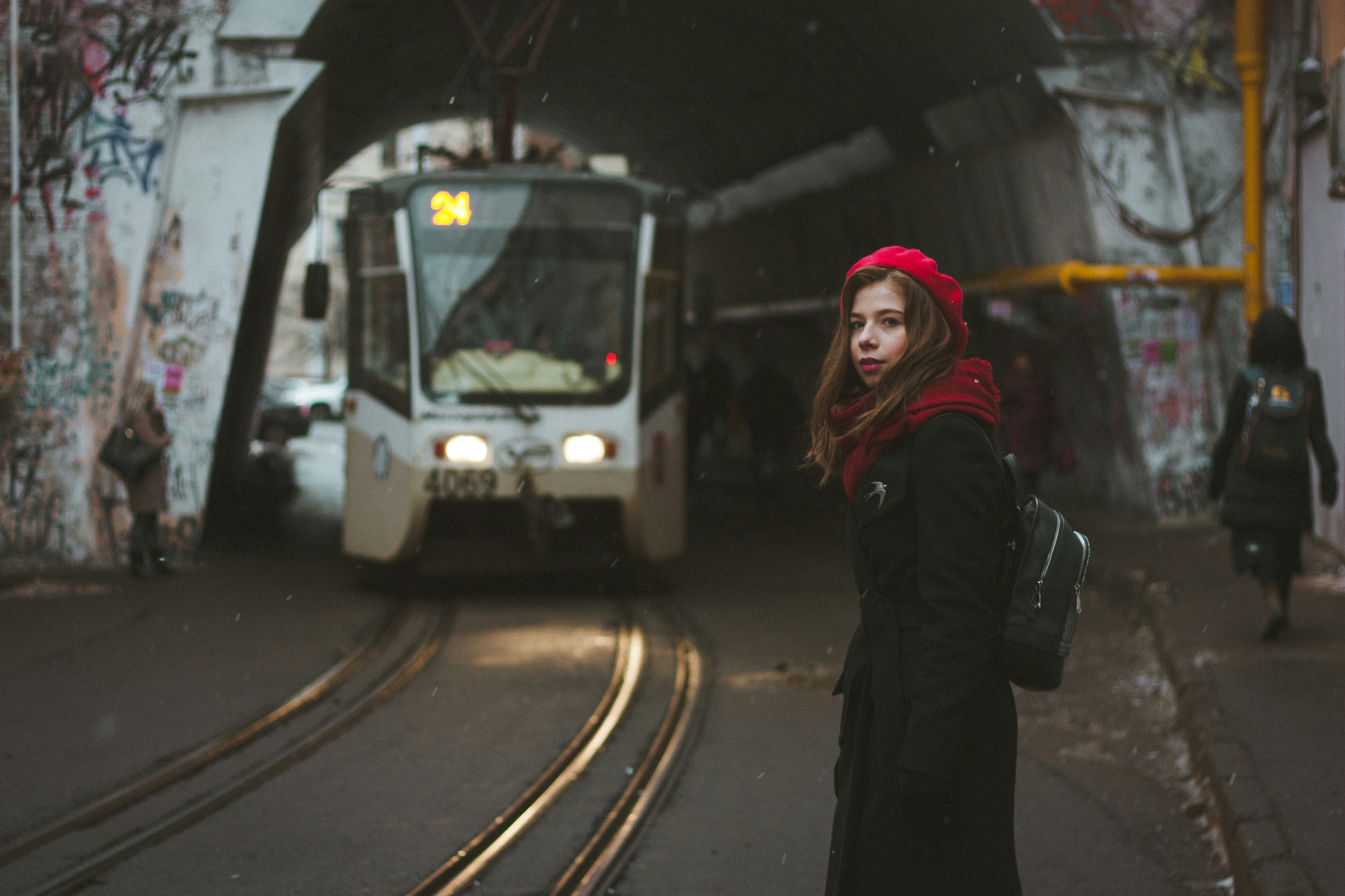 Crimson Beret at the Tram Threshold: A Quiet Portrait on Urban Rails
