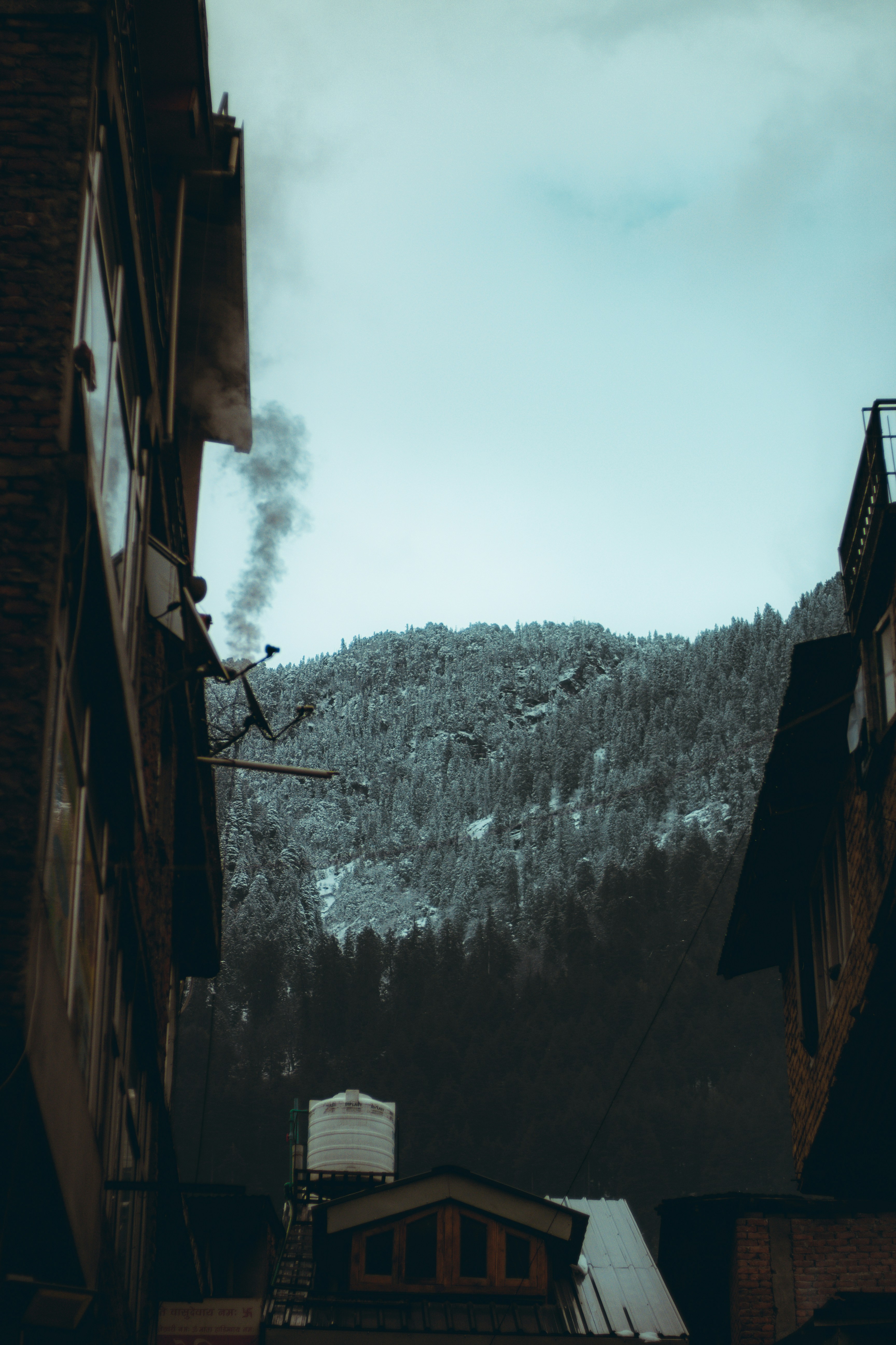 a view of a mountain from a narrow alley way