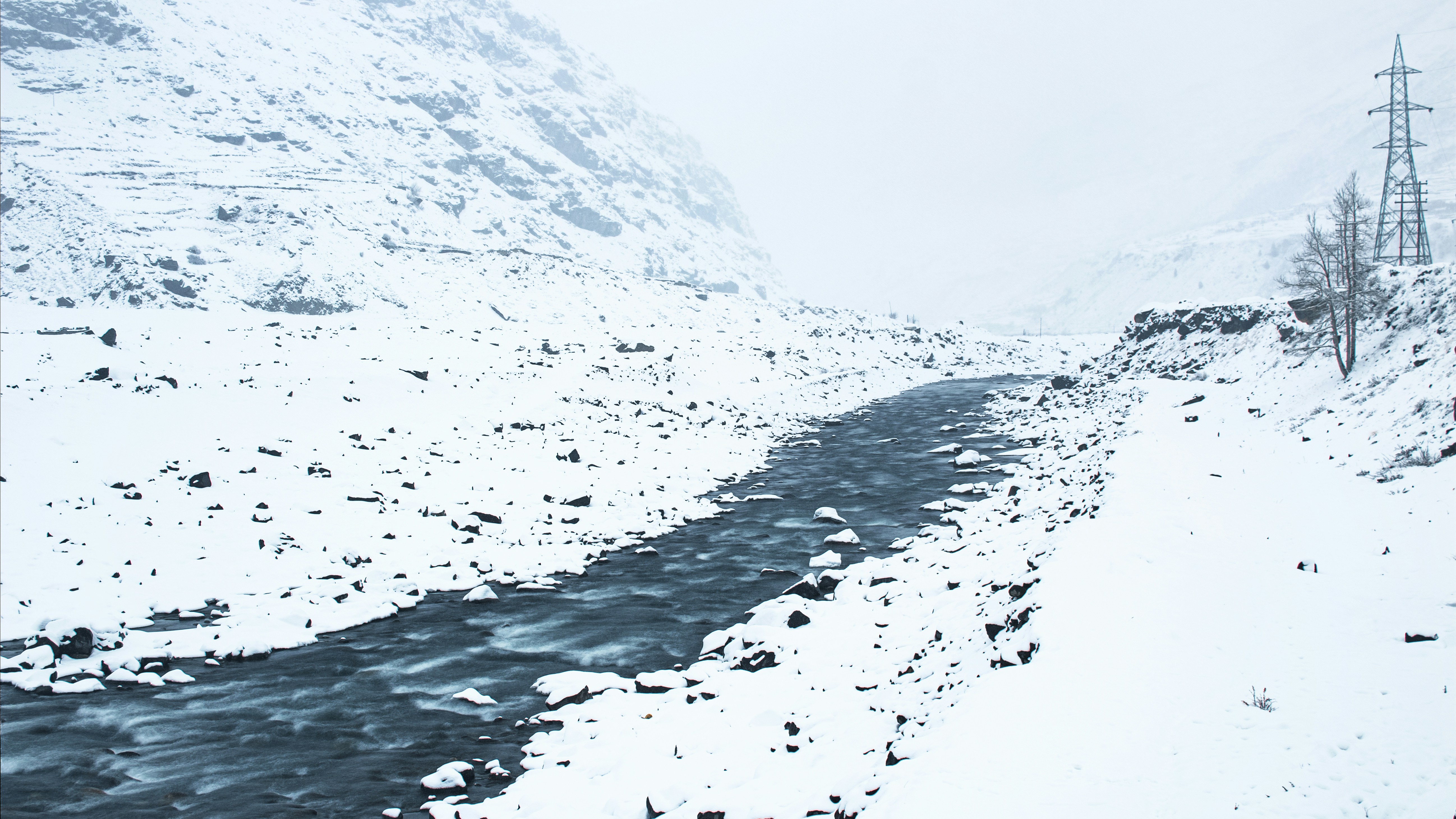 A river running through a snow covered mountain side photo – Free Sissu ...