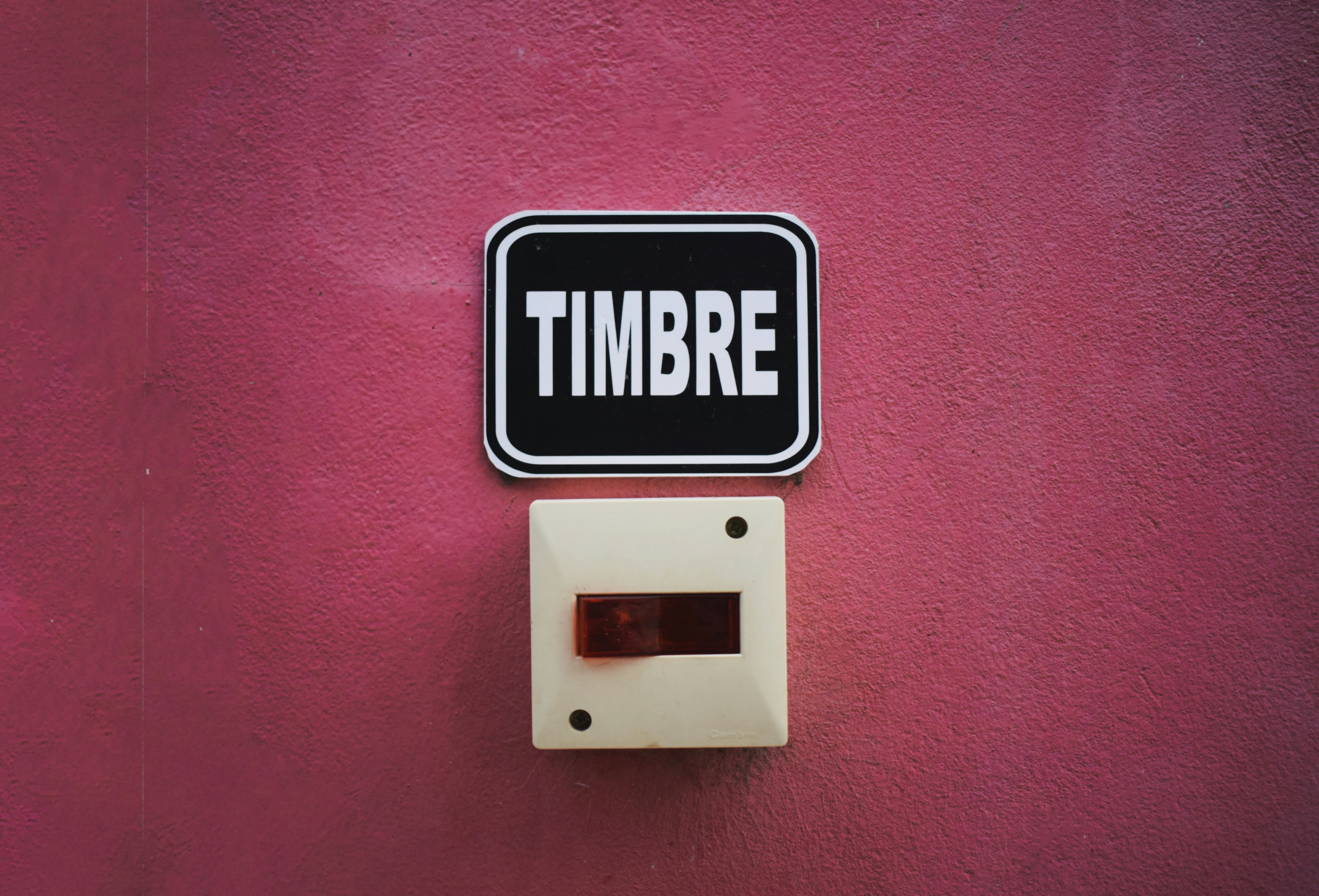 Foto Un letrero en una pared rosa que dice timbre – Imagen Etiqueta ...